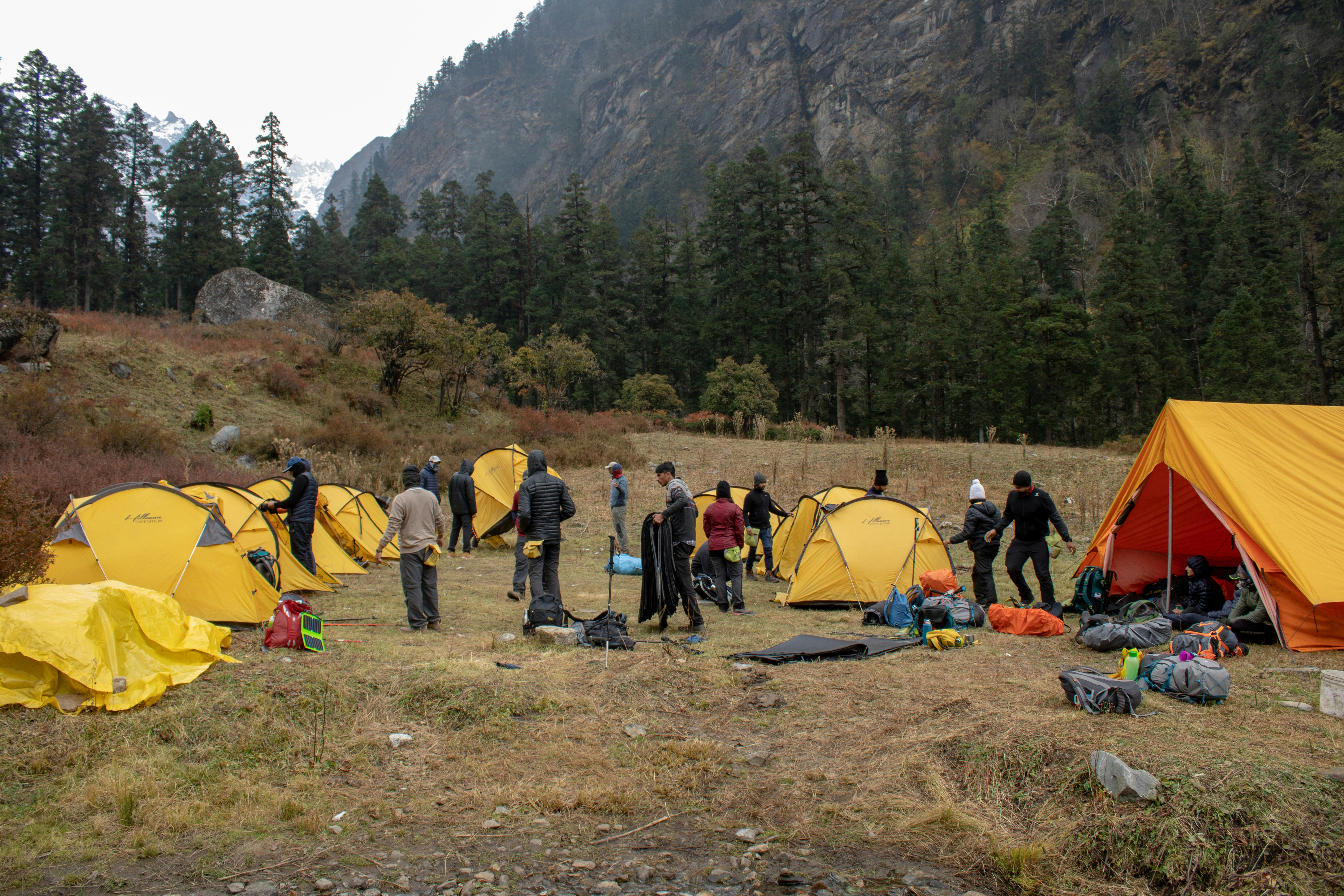 a group of people standing around a yellow tent
