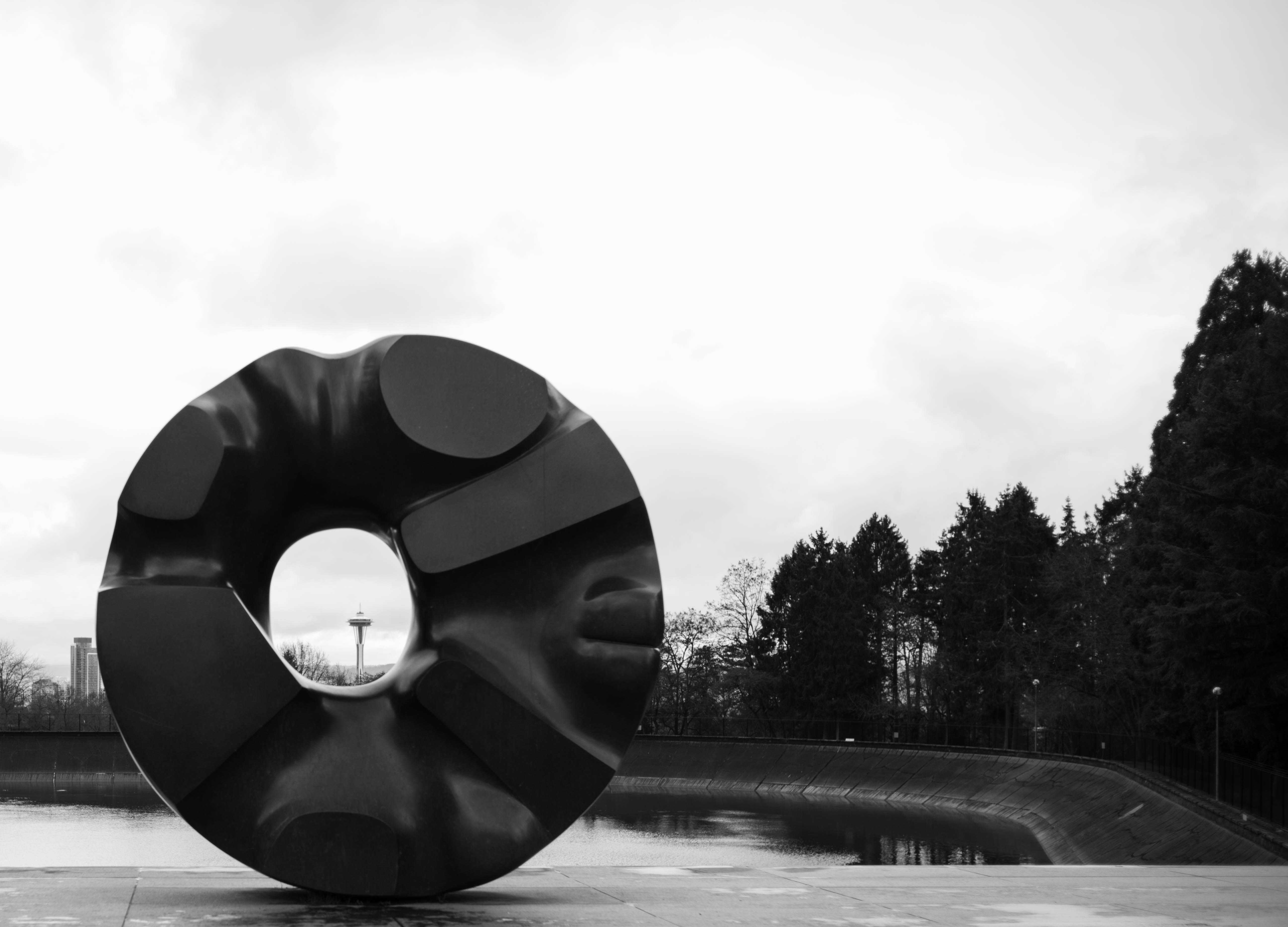 Circular sculpture by the water: a monochrome moment
