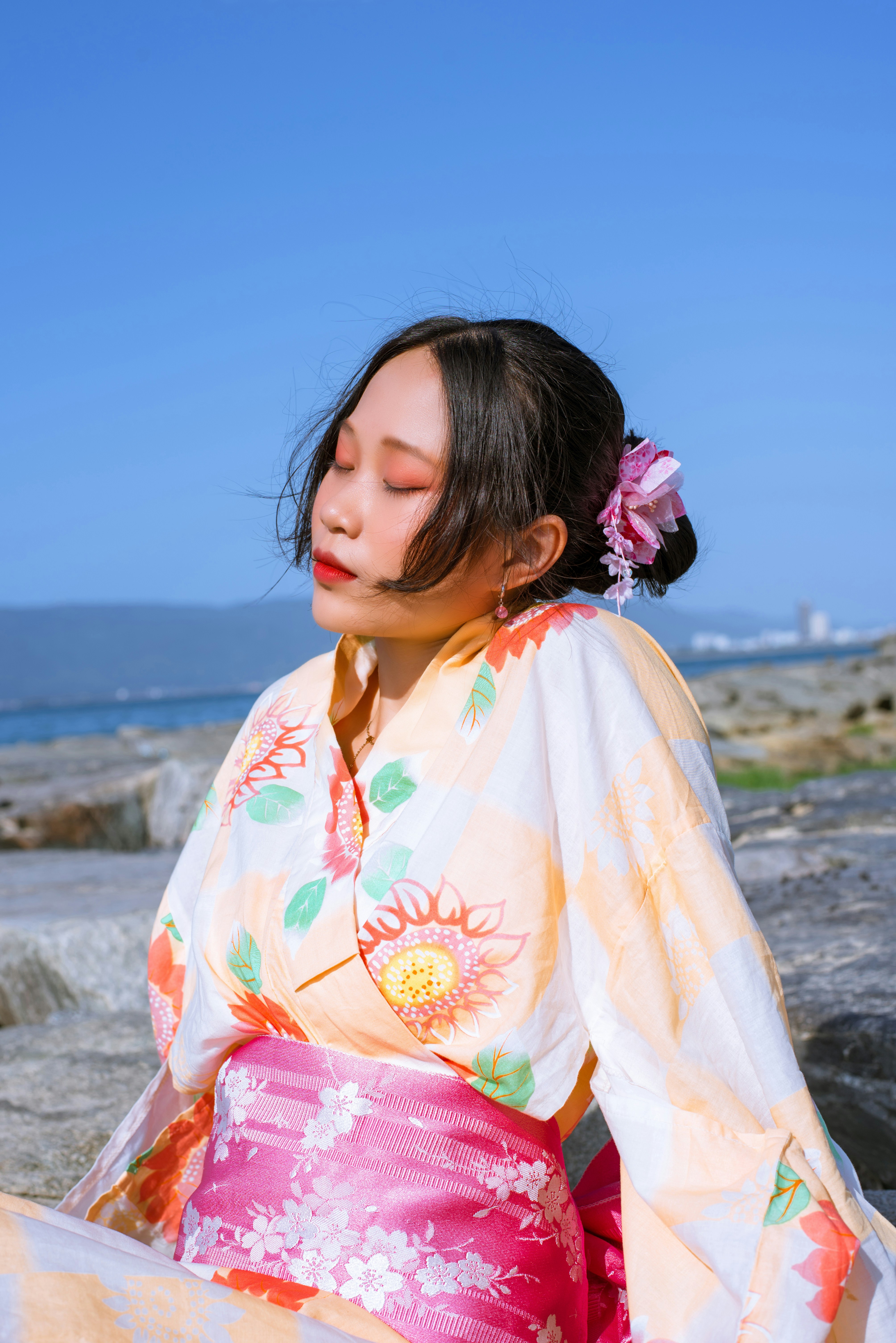 a woman in a kimono standing on a beach