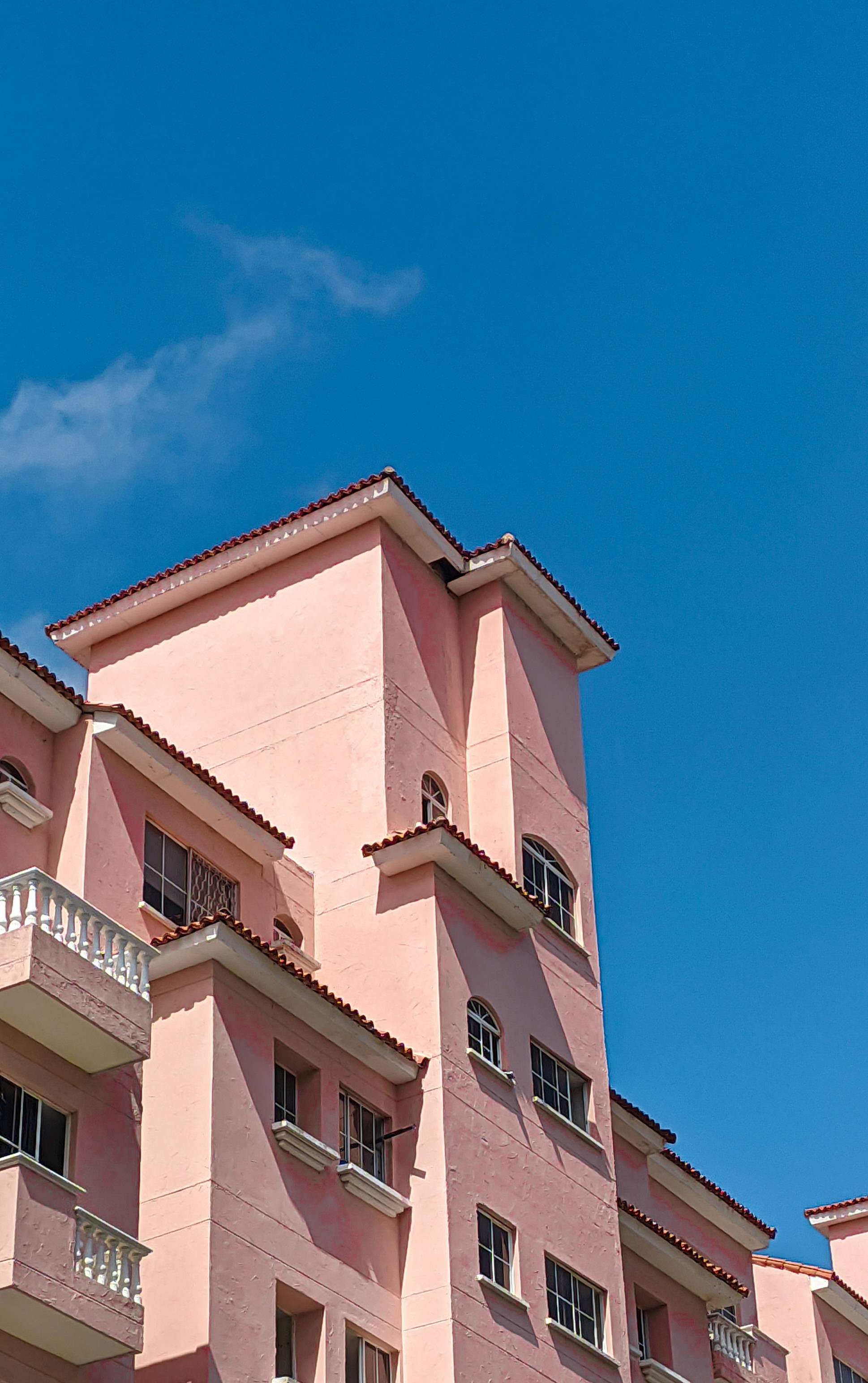 Un edificio rosa con balcones y una torre del reloj foto – Imagen de ...