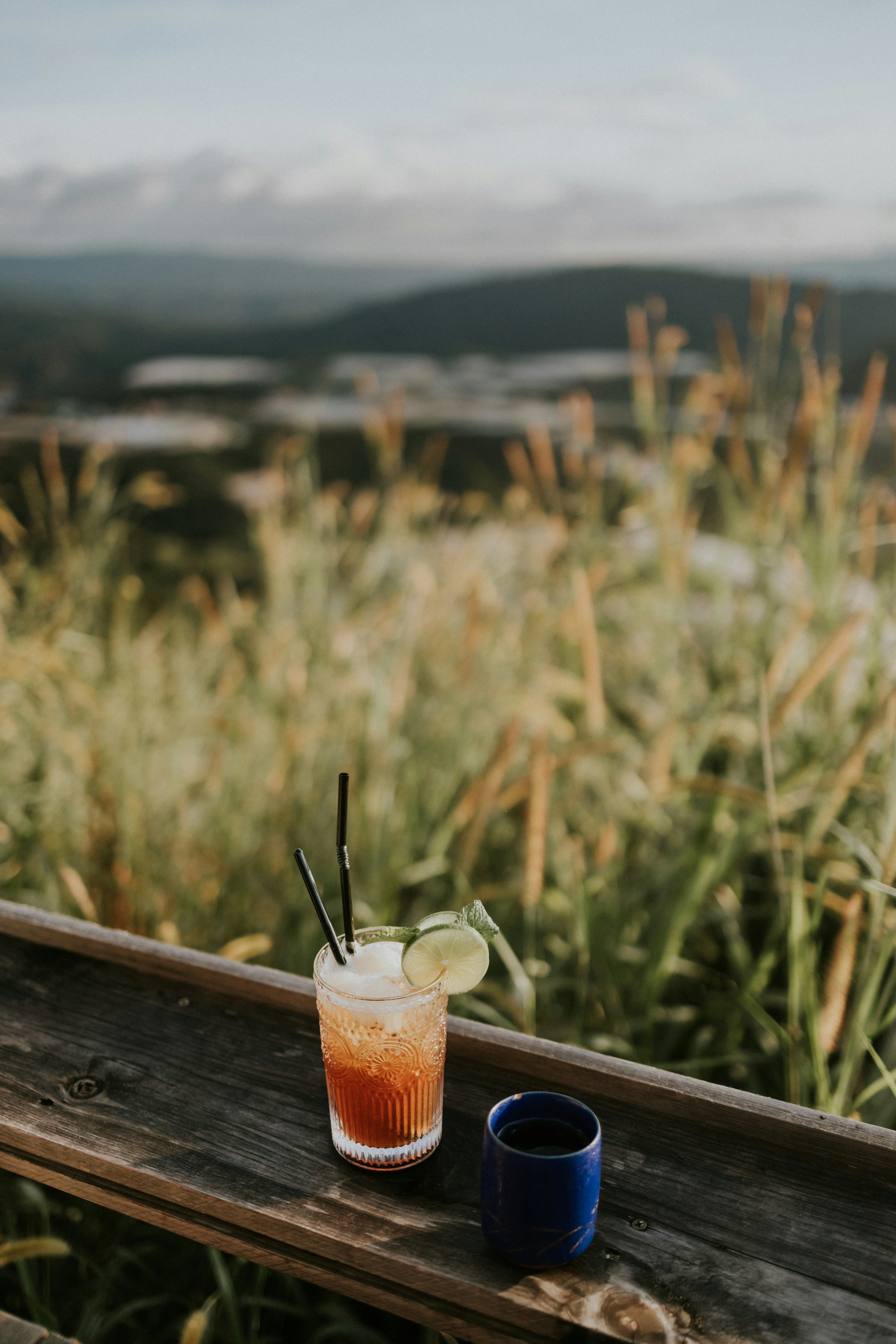 Veranda Vista: A Citrus Cocktail Framed by Golden Grass and Distant Hills