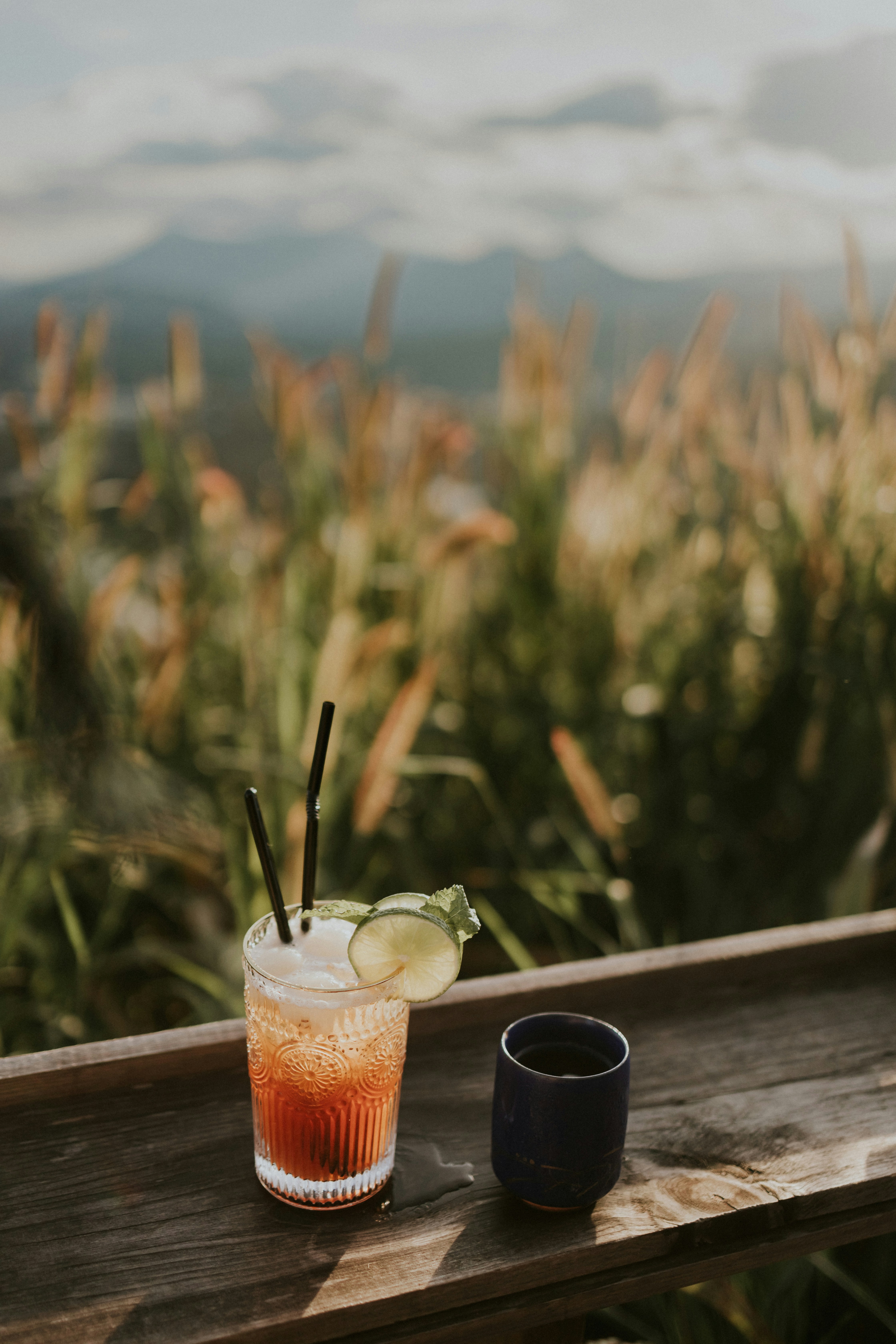 a drink with a slice of cucumber on a wooden table