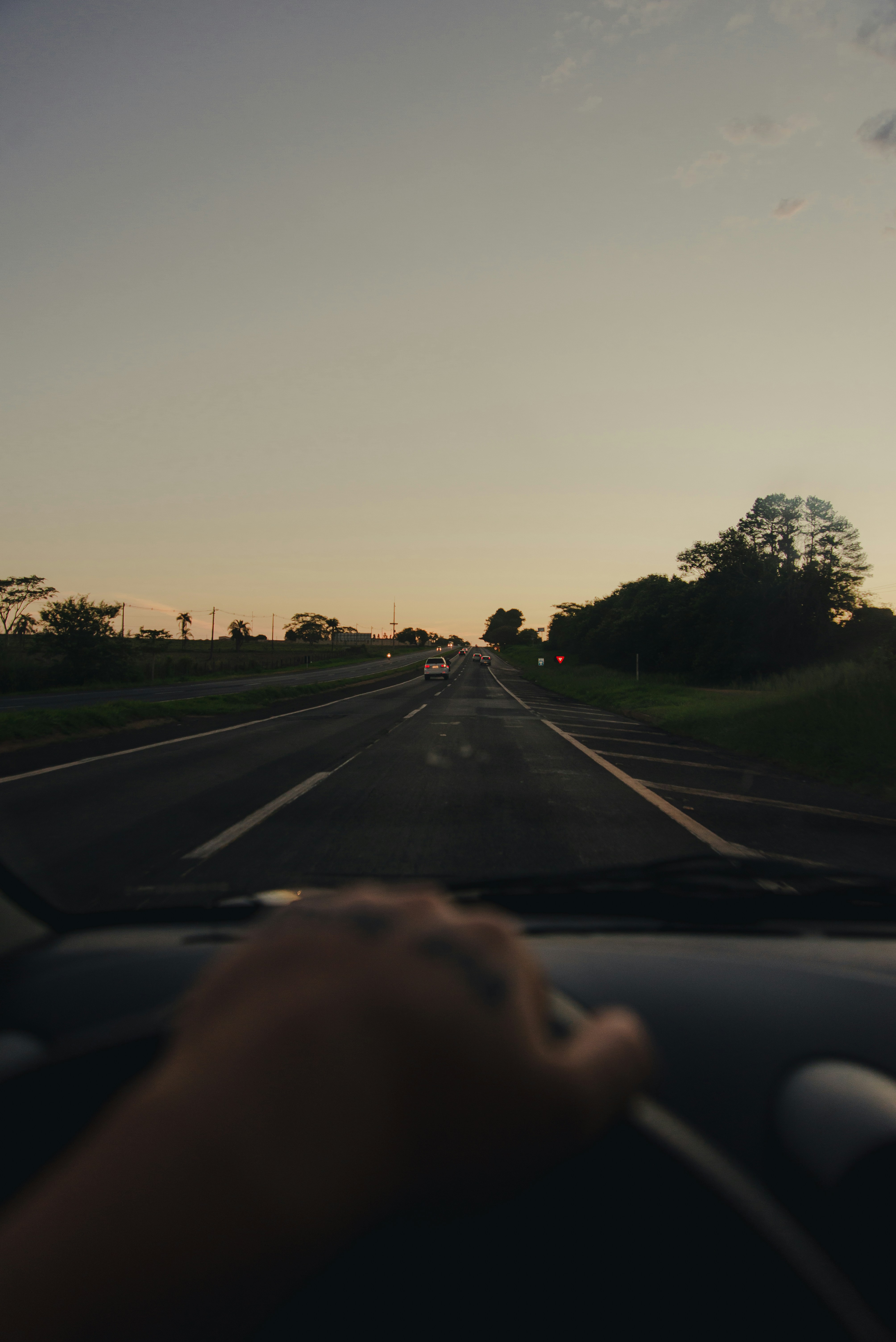 Una persona conduciendo un automóvil por una carretera al atardecer ...