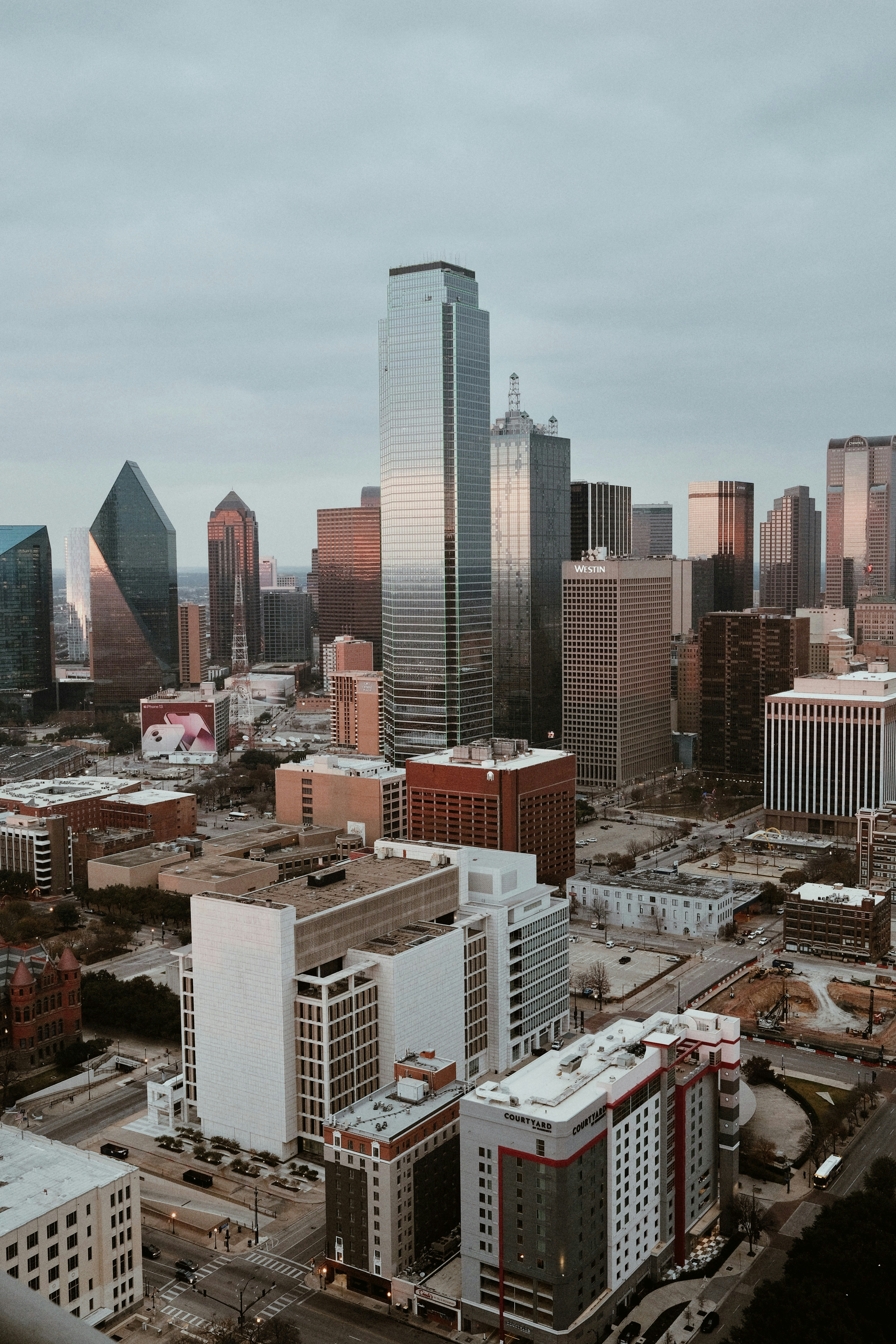 Aerial view of a bustling city skyline featuring modern skyscrapers and architectural diversity, captured during the golden hour.