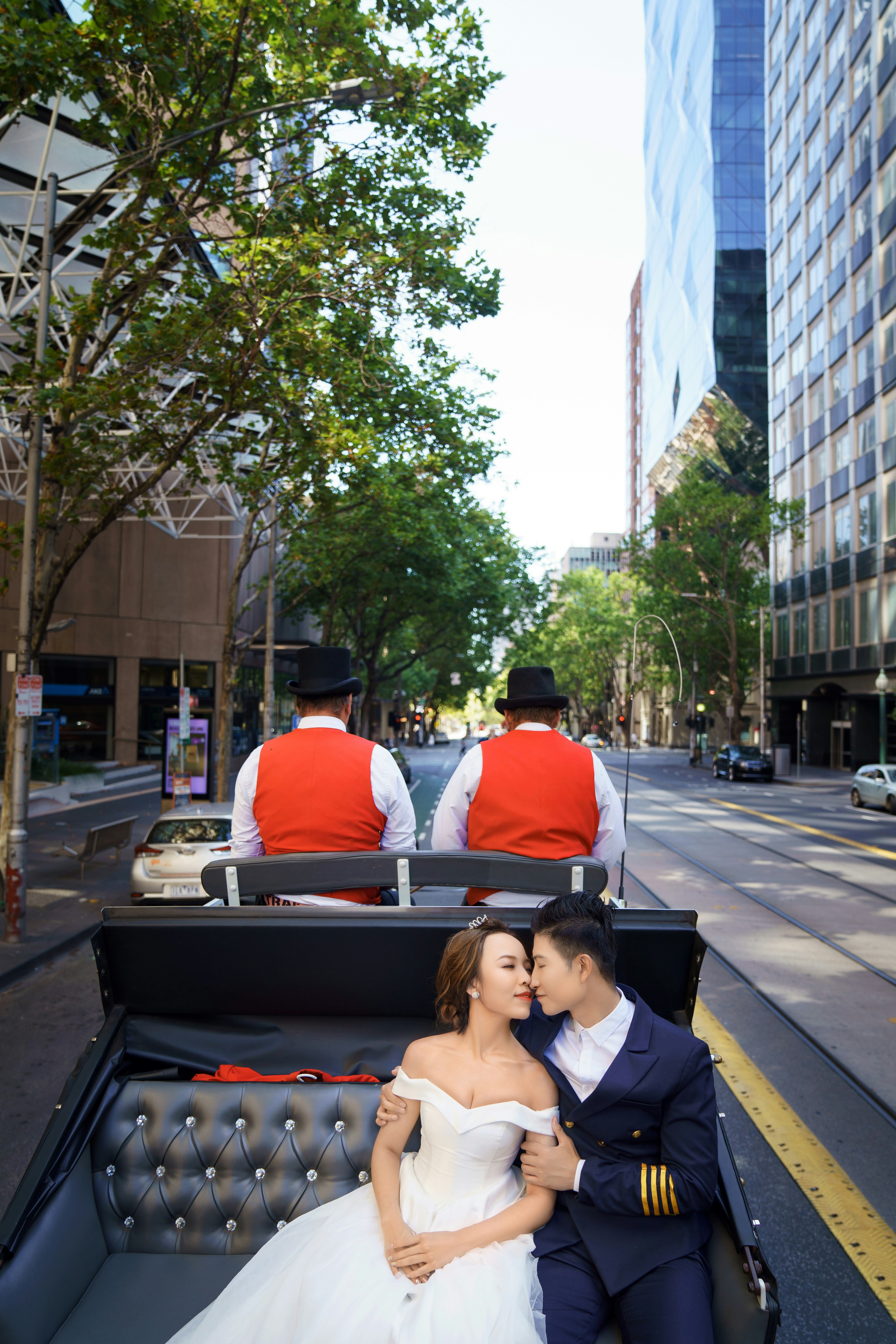 Downtown carriage kiss: a wedding moment amid glass towers and green avenues