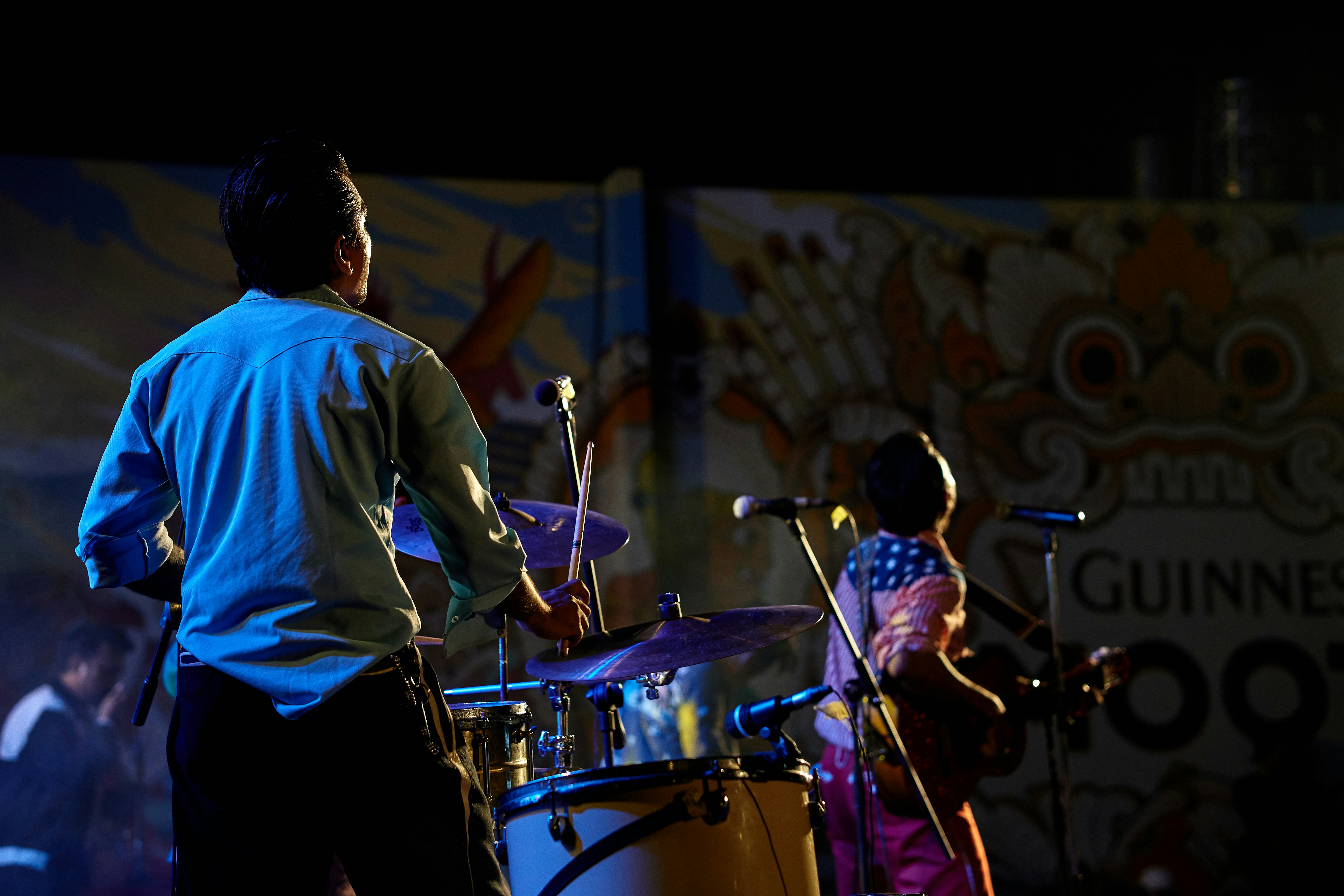 A man playing drums while another man plays the drums photo – Free ...