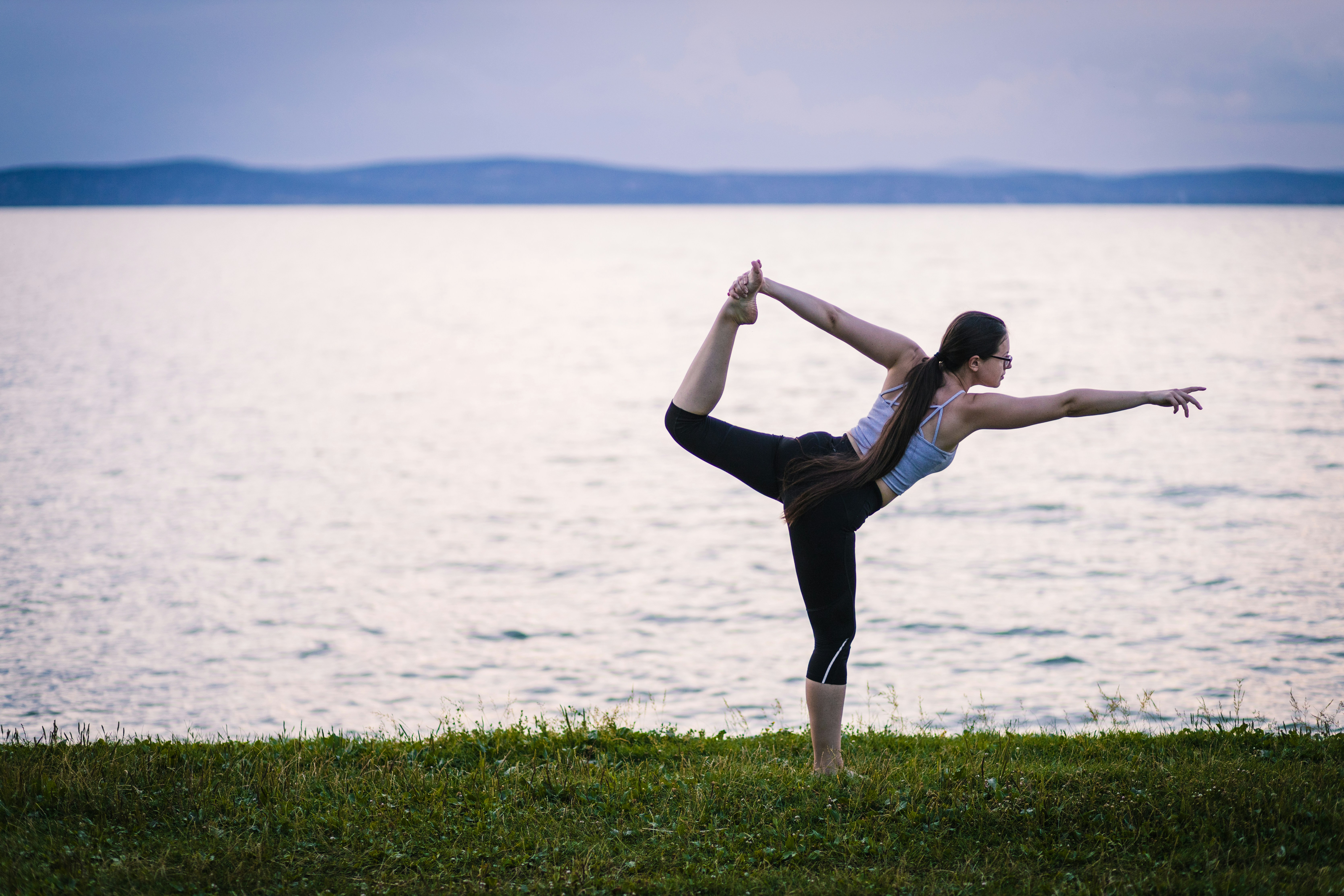 A woman doing a yoga pose by the water photo – Free Sport Image on Unsplash