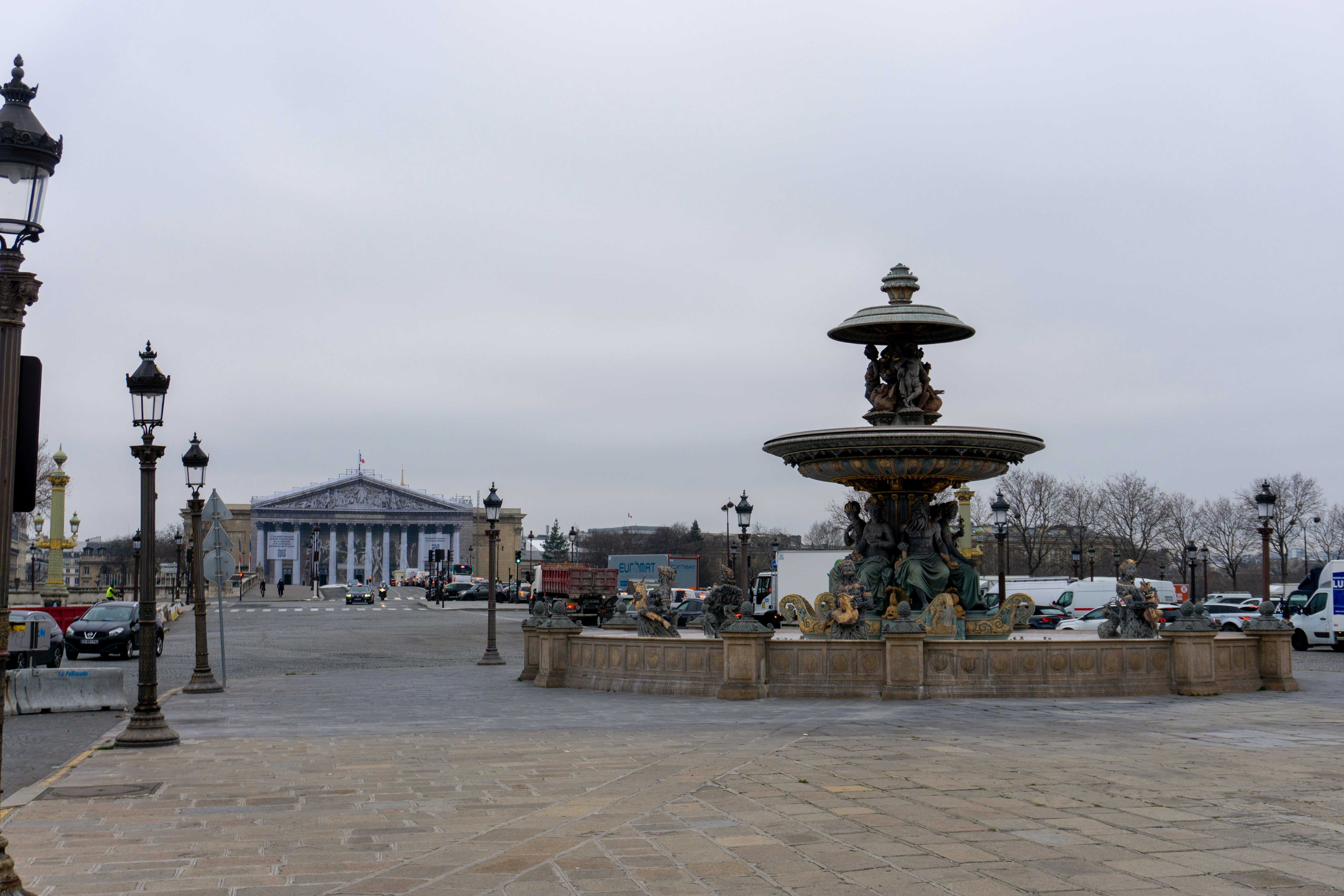 Ornate Fountain Anchoring a Quiet European Square Beneath an Overcast Sky