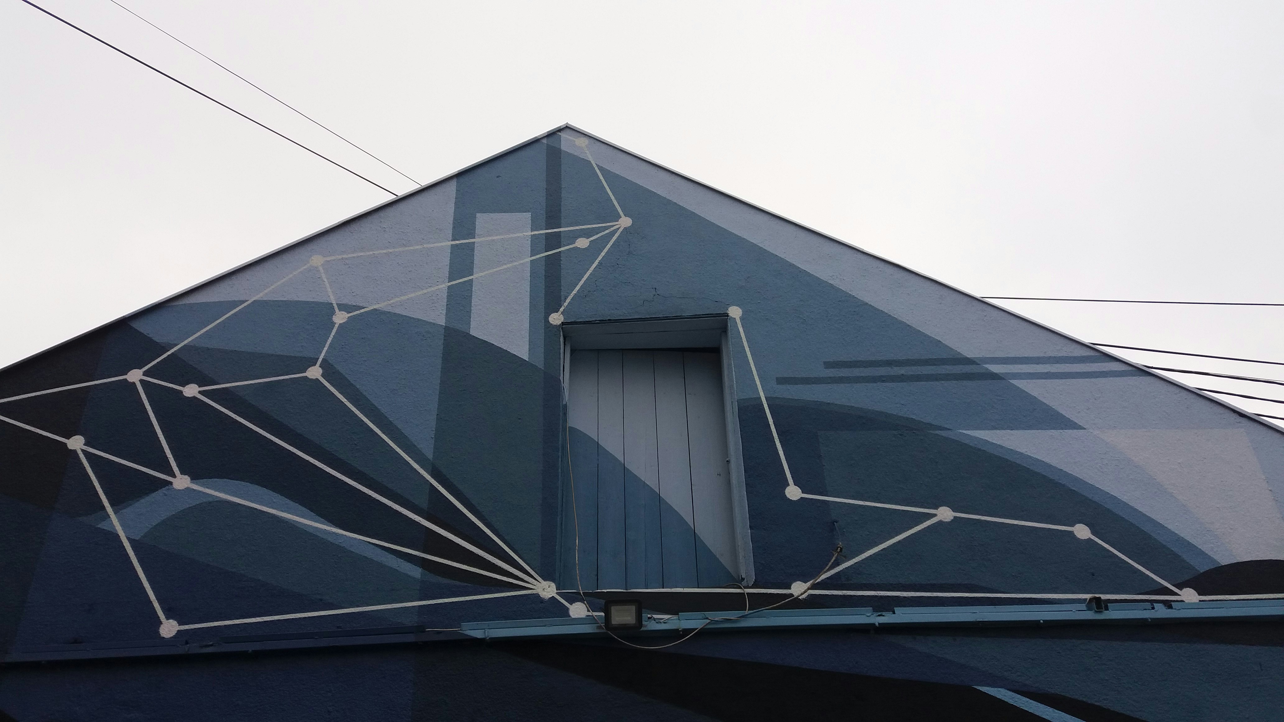 a blue building with lines painted on the side of it