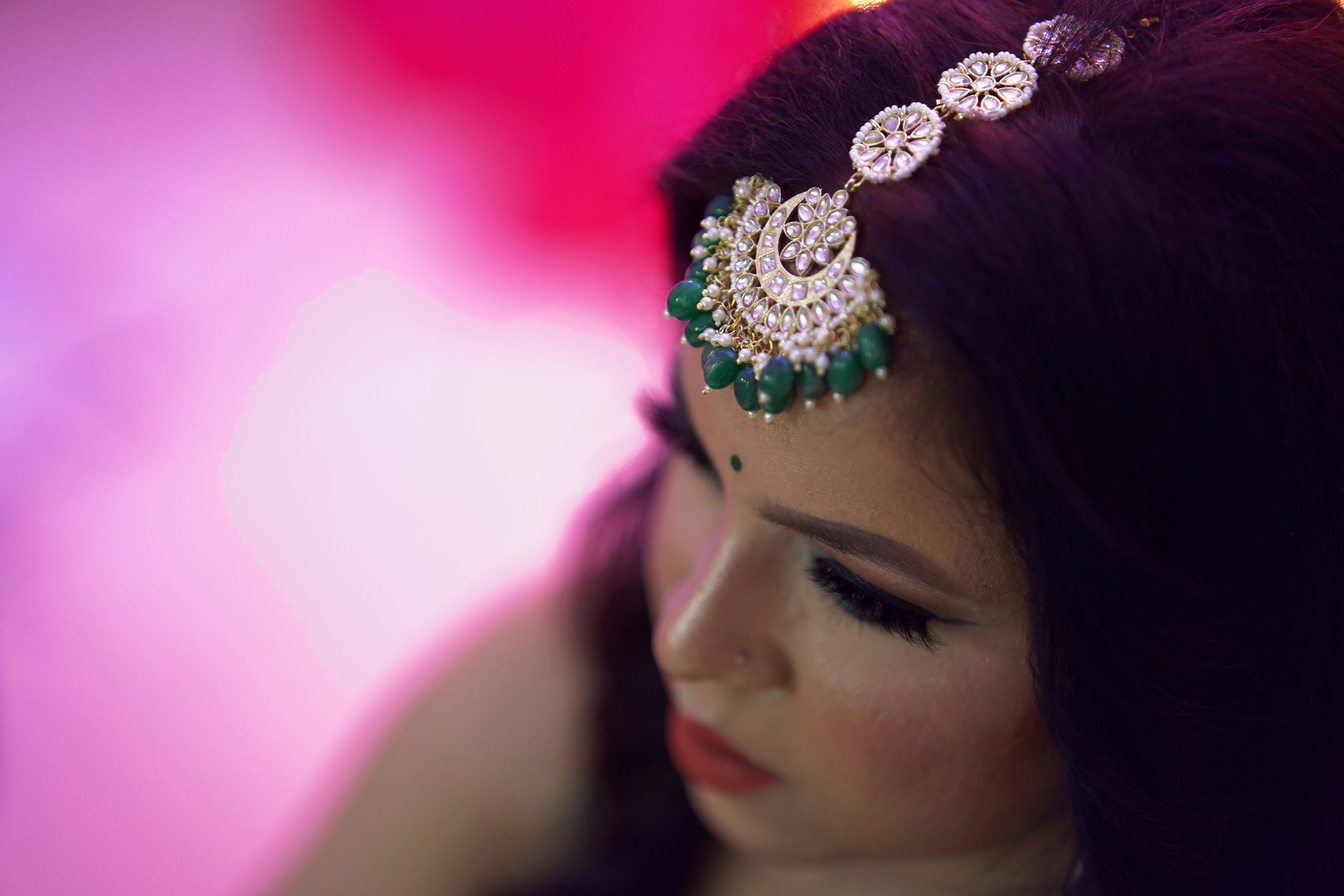 Gilded forehead jewel in a hazy pink veil
