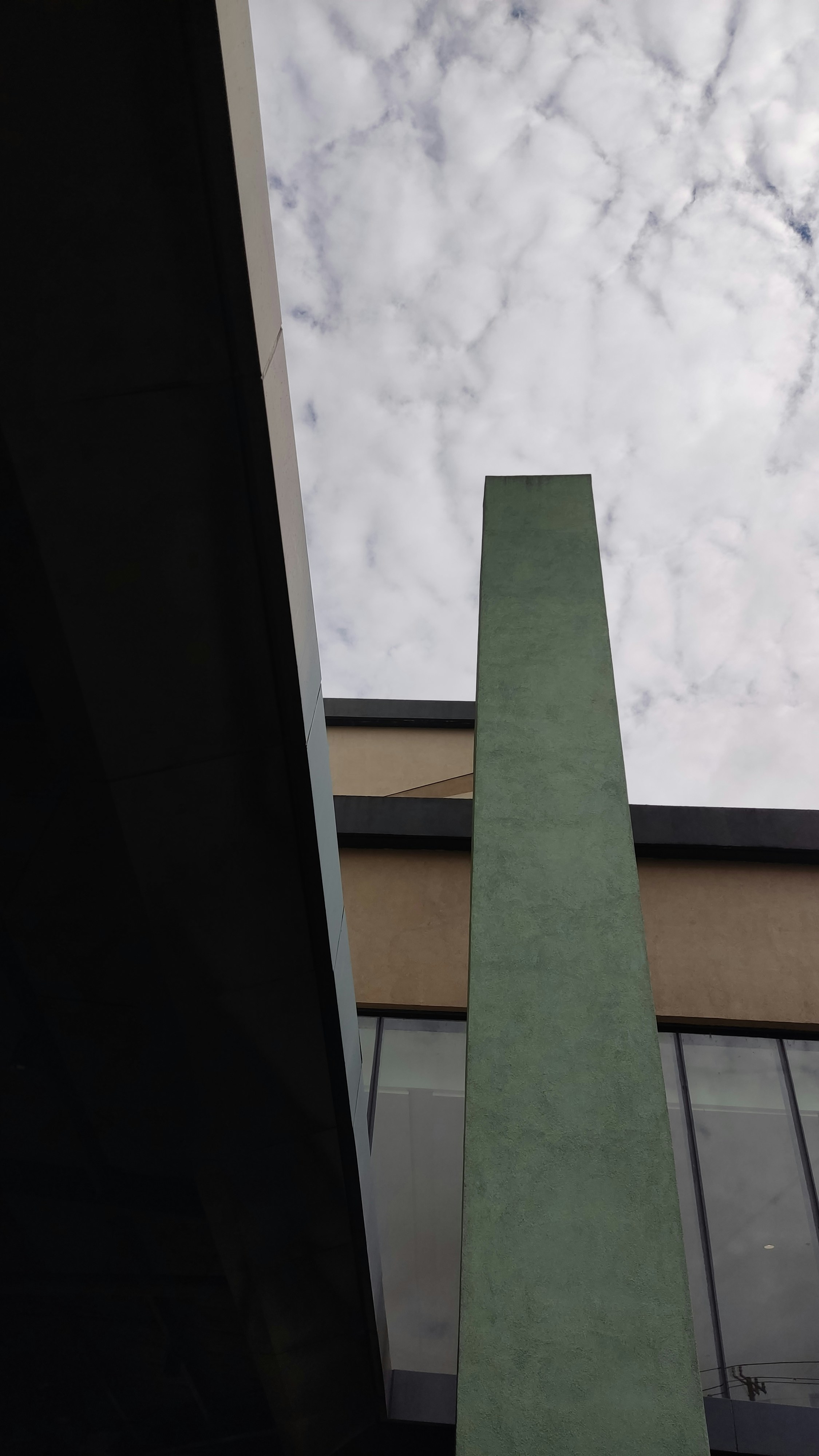 Vertical Green Pillar Framing a Cloudy Sky: An Urban Geometry Study