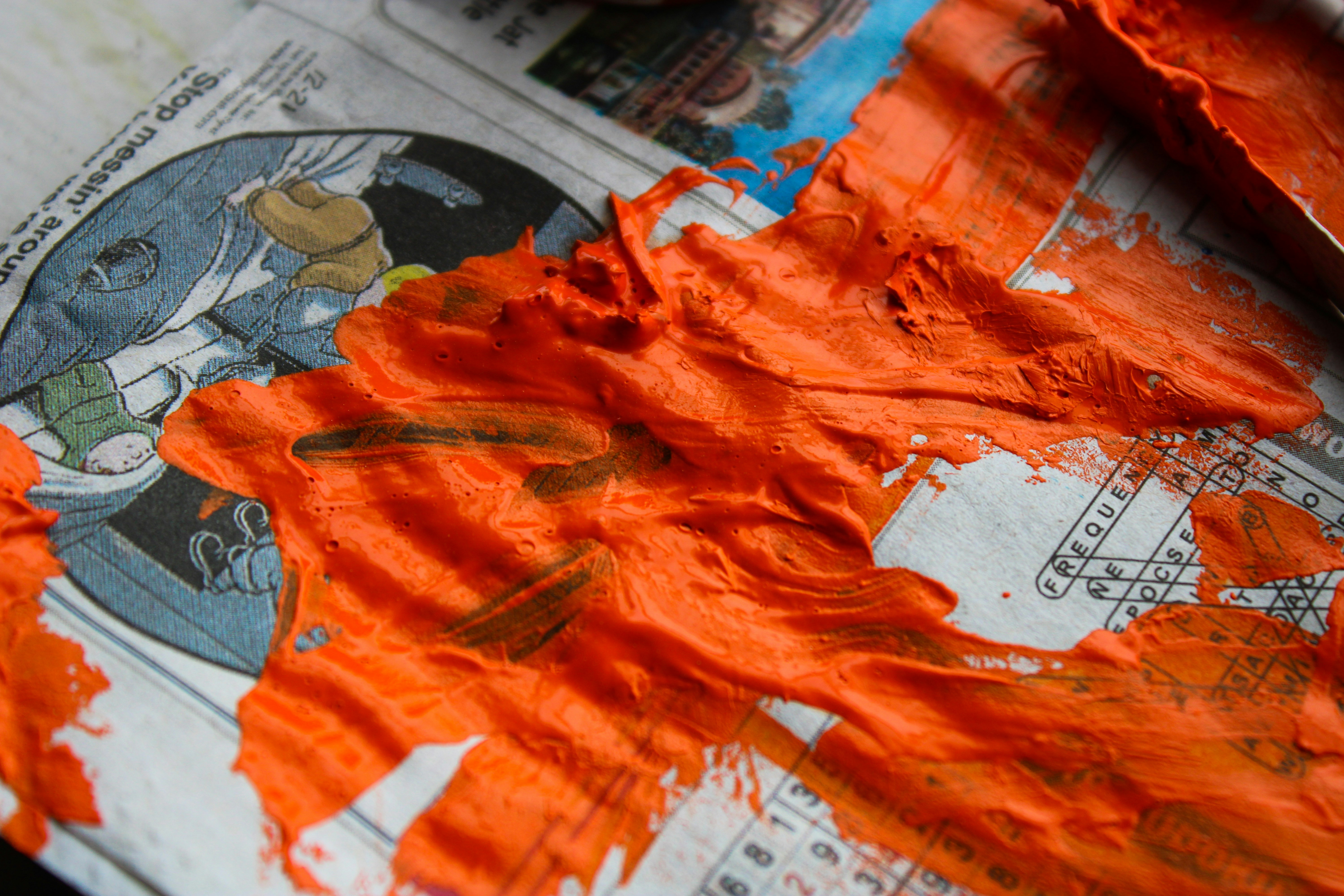 Crushed Orange Paint on Printed Paper: Abstract Texture and Fragments