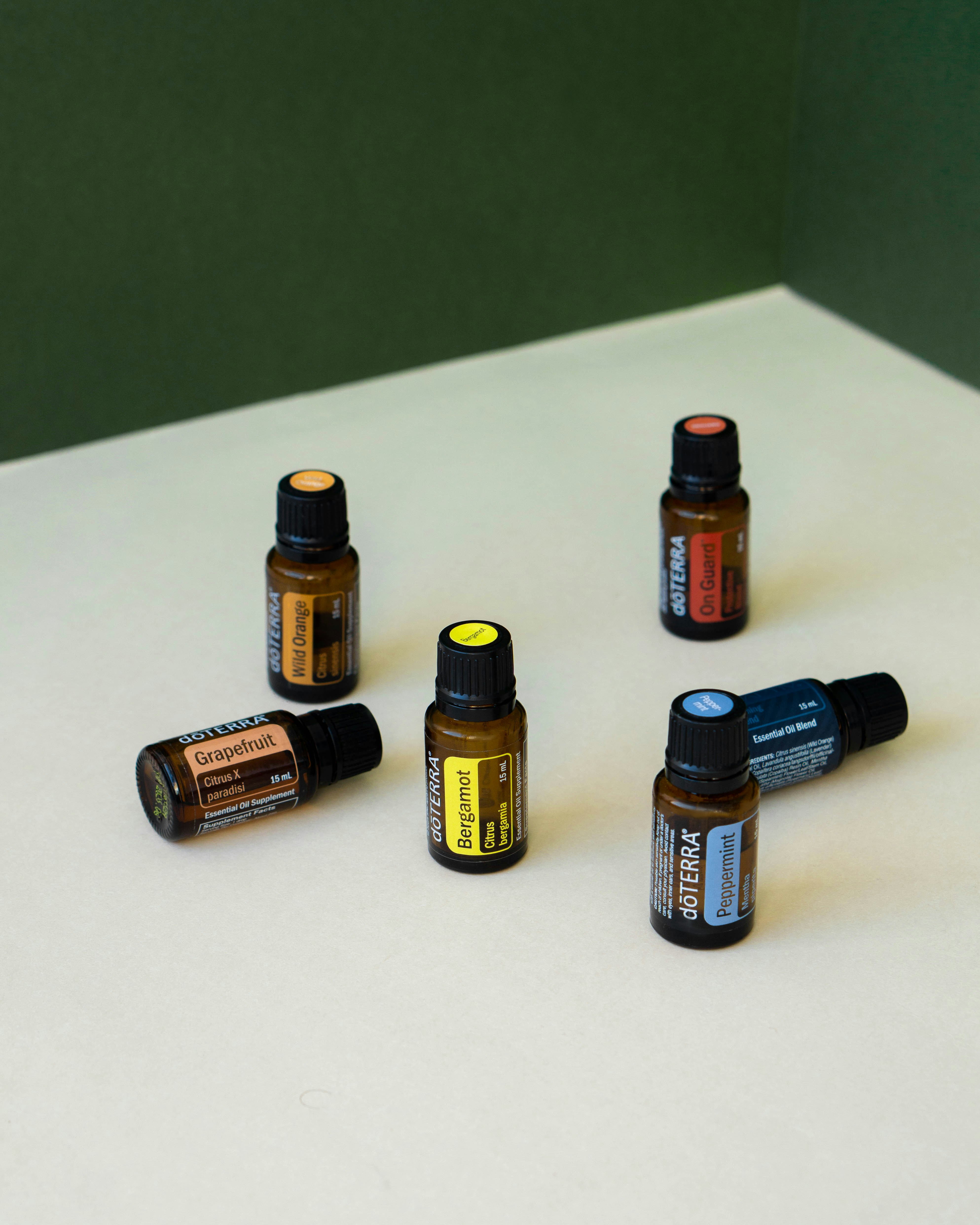 Collection of essential oil bottles arranged on a neutral background, showcasing various scents and colors. Each bottle is labeled for easy identification.