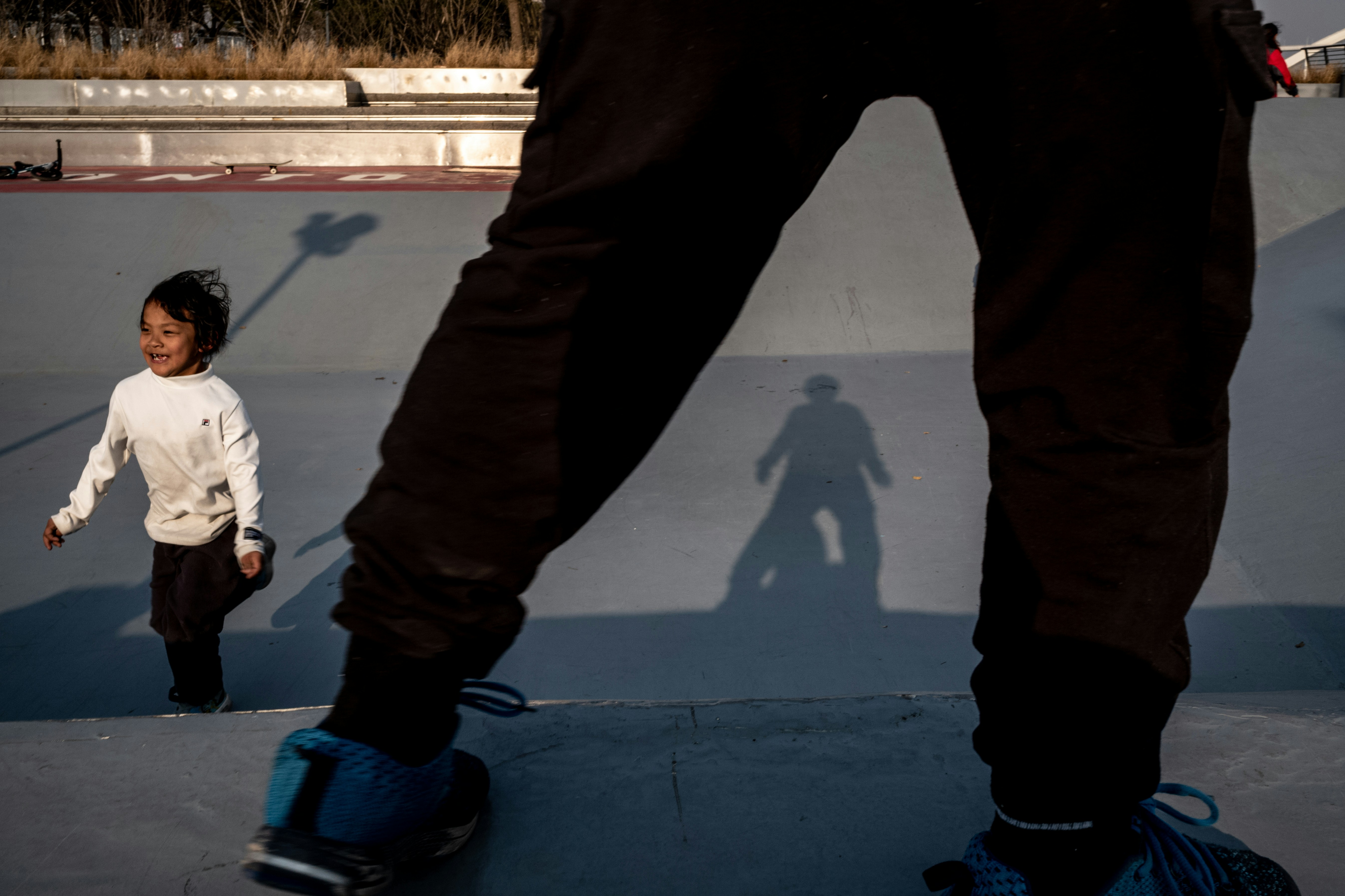 A young child standing on a skateboard at a skate park photo – Free ...