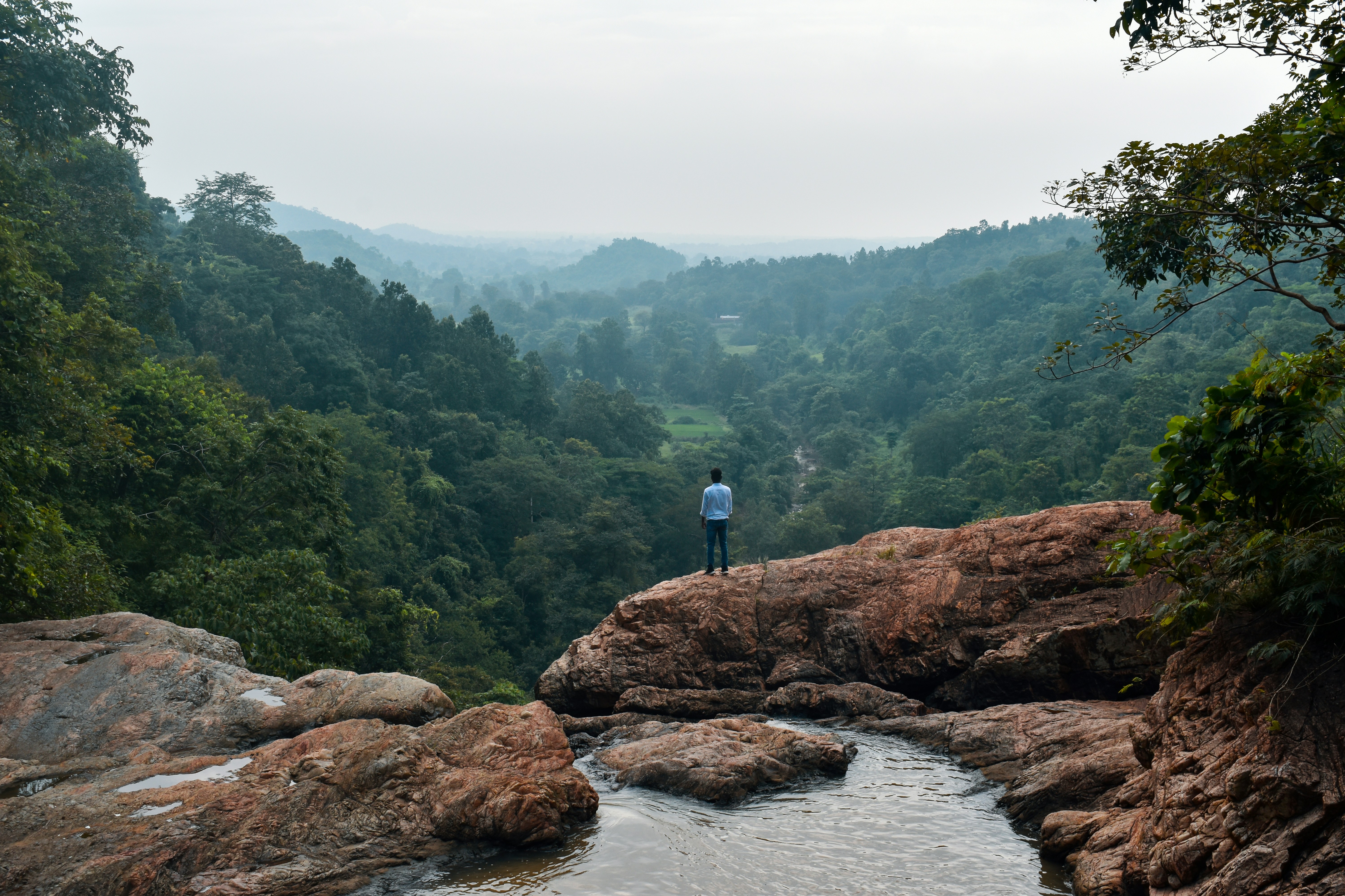 A man standing on top of a rock next to a river photo – Free Tiru fall ...