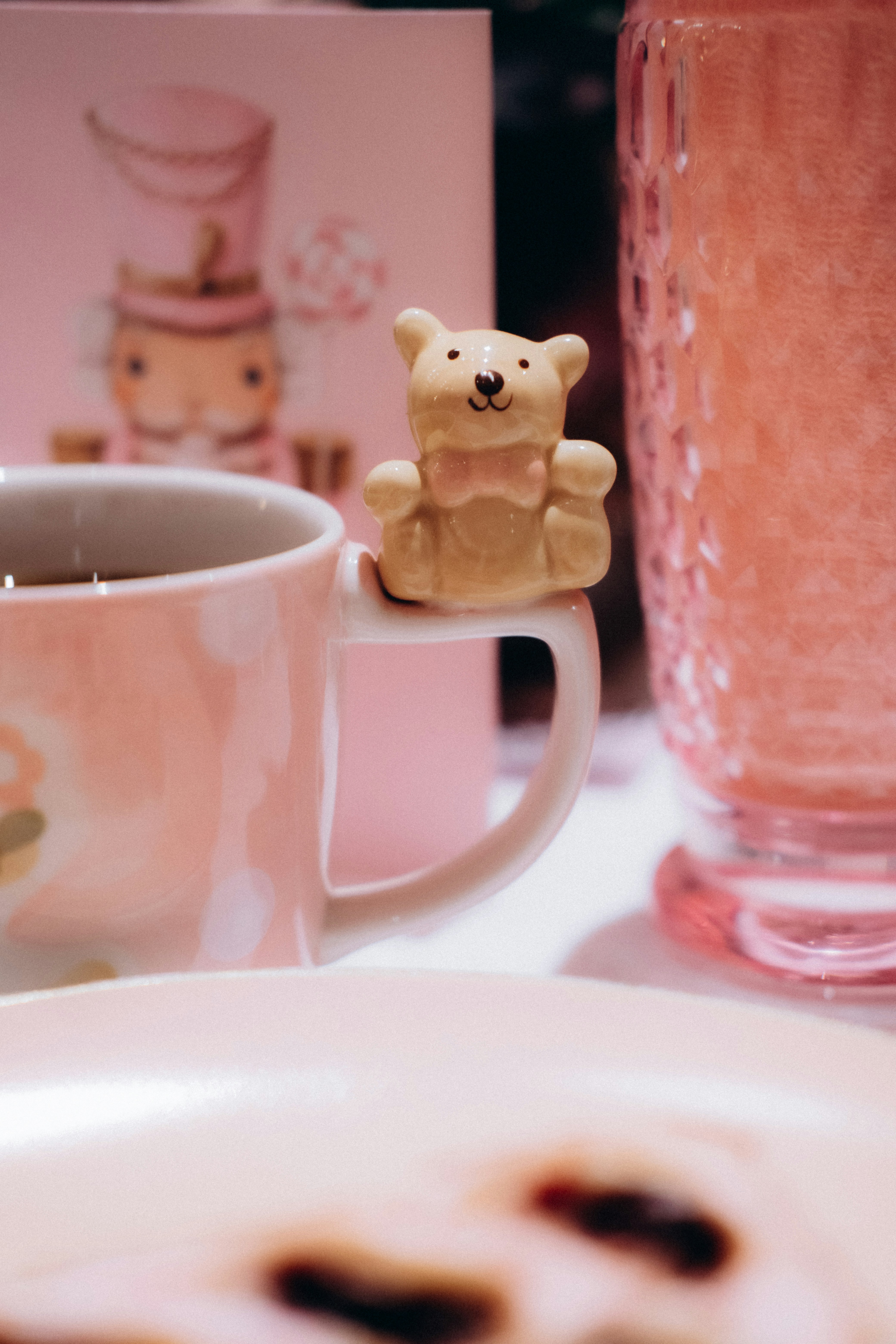 Handlebound Whimsy: A Tiny Bear Grips a Teacup in Soft Pink Light