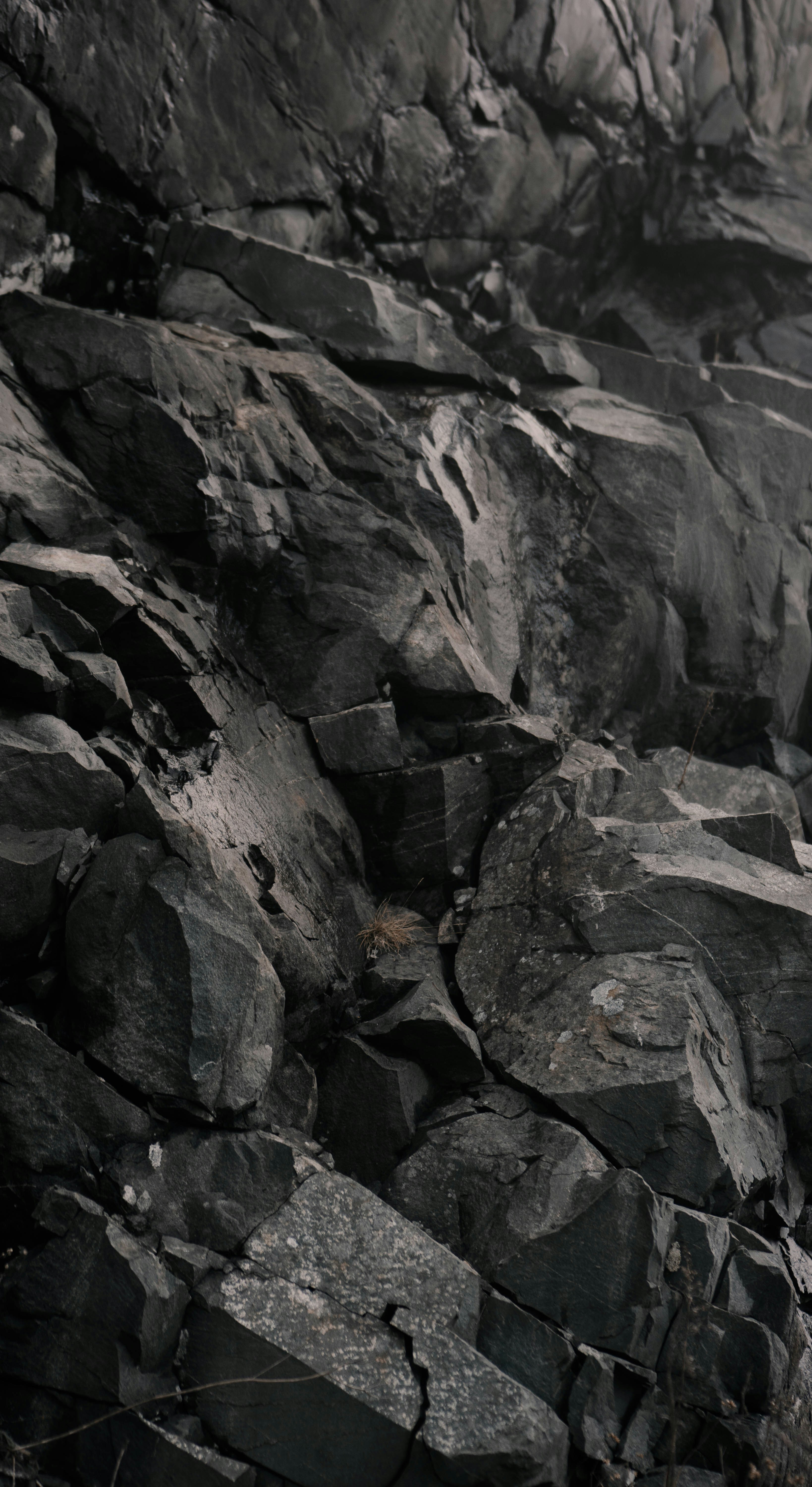 Intricate patterns of dark, weathered rocks showcasing the raw beauty of nature's geology.