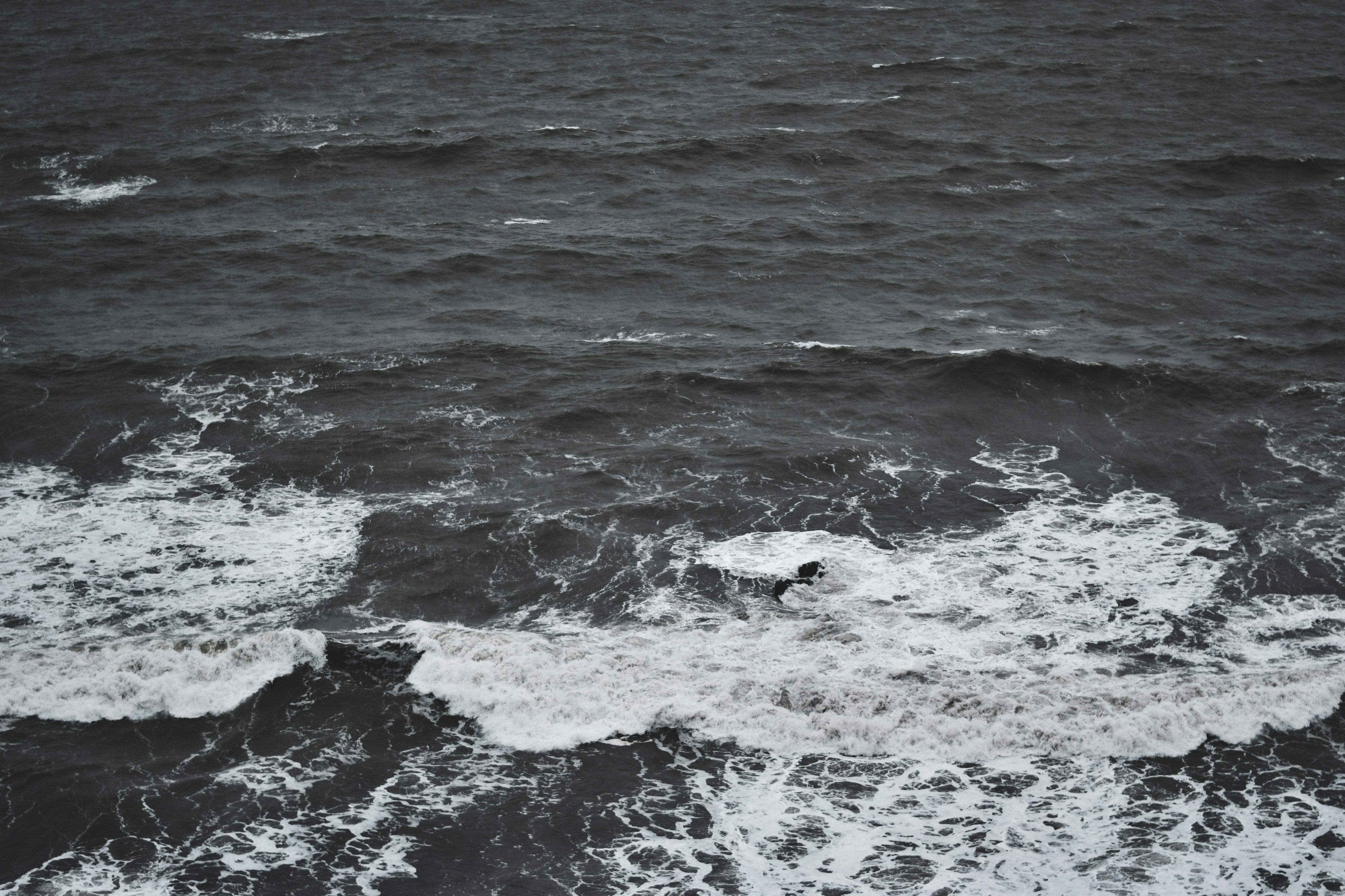 Rough sea waves crashing against a rocky outcrop, creating a dynamic interplay of water and foam.