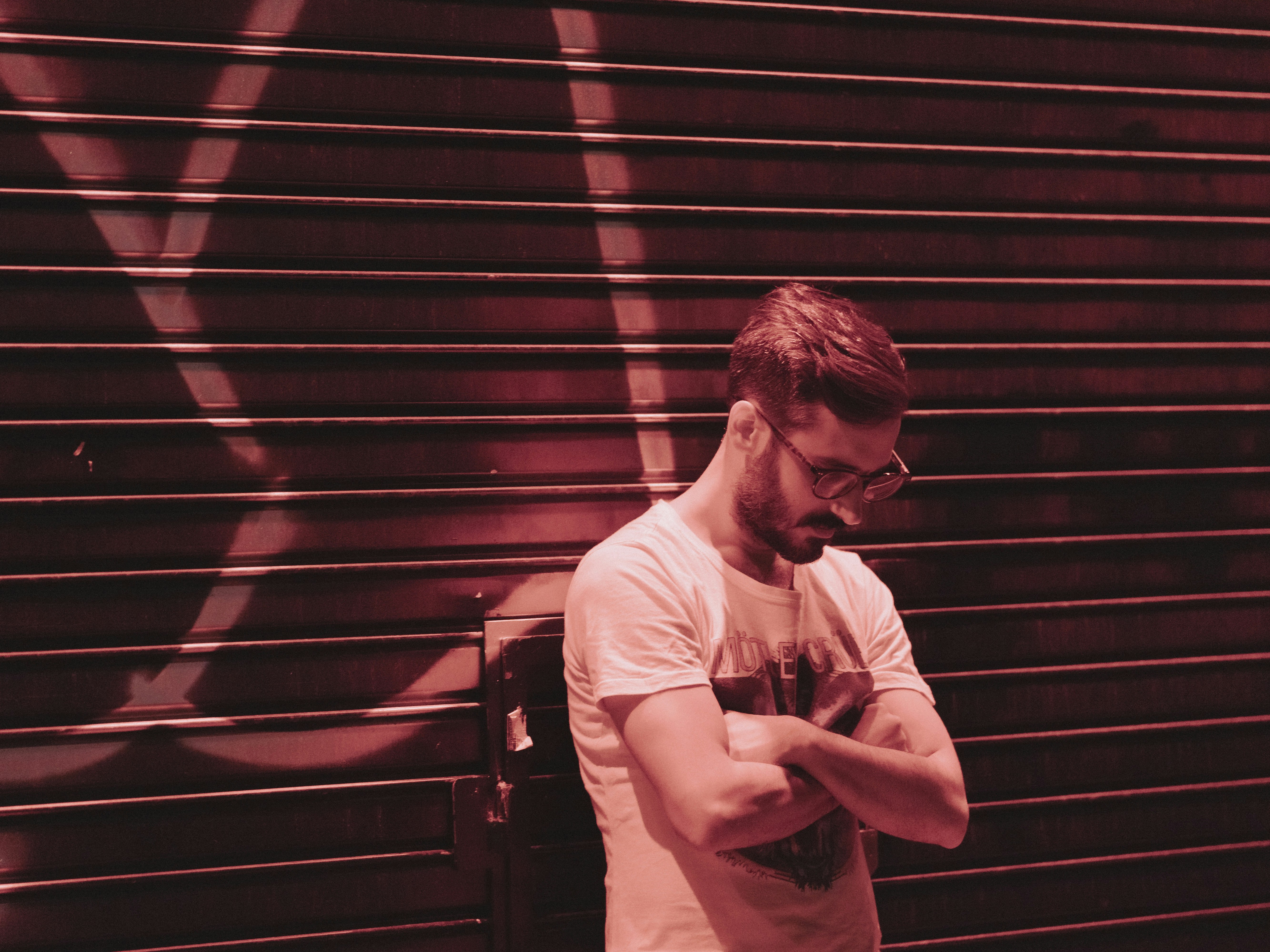 Crimson Quiet: A Contemplative Portrait Against Graffitied Shutters