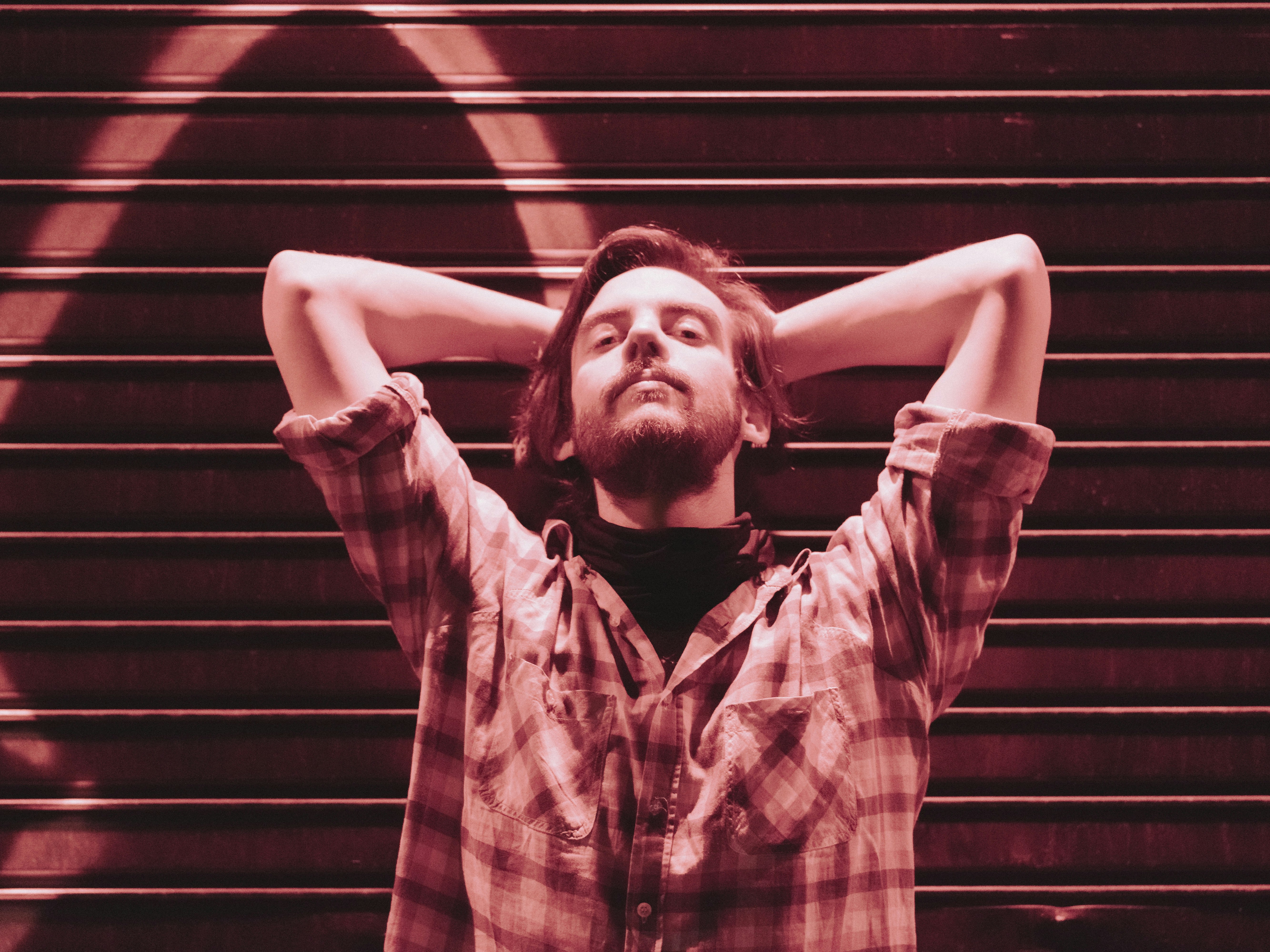 Crimson Lines, Quiet Confidence: Portrait Beneath a Red Backdrop