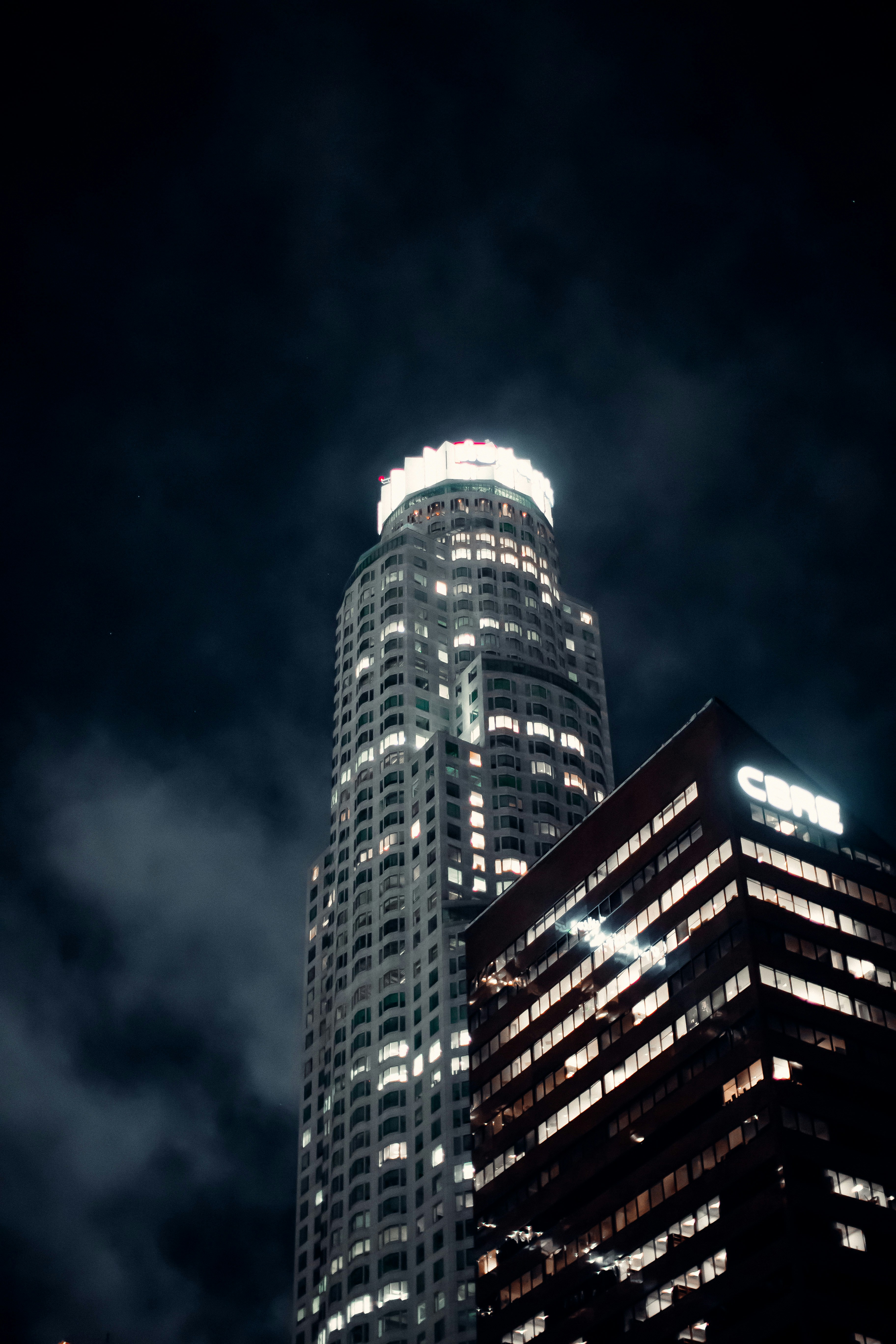 A very tall building lit up at night photo – Free Downtown Image on ...