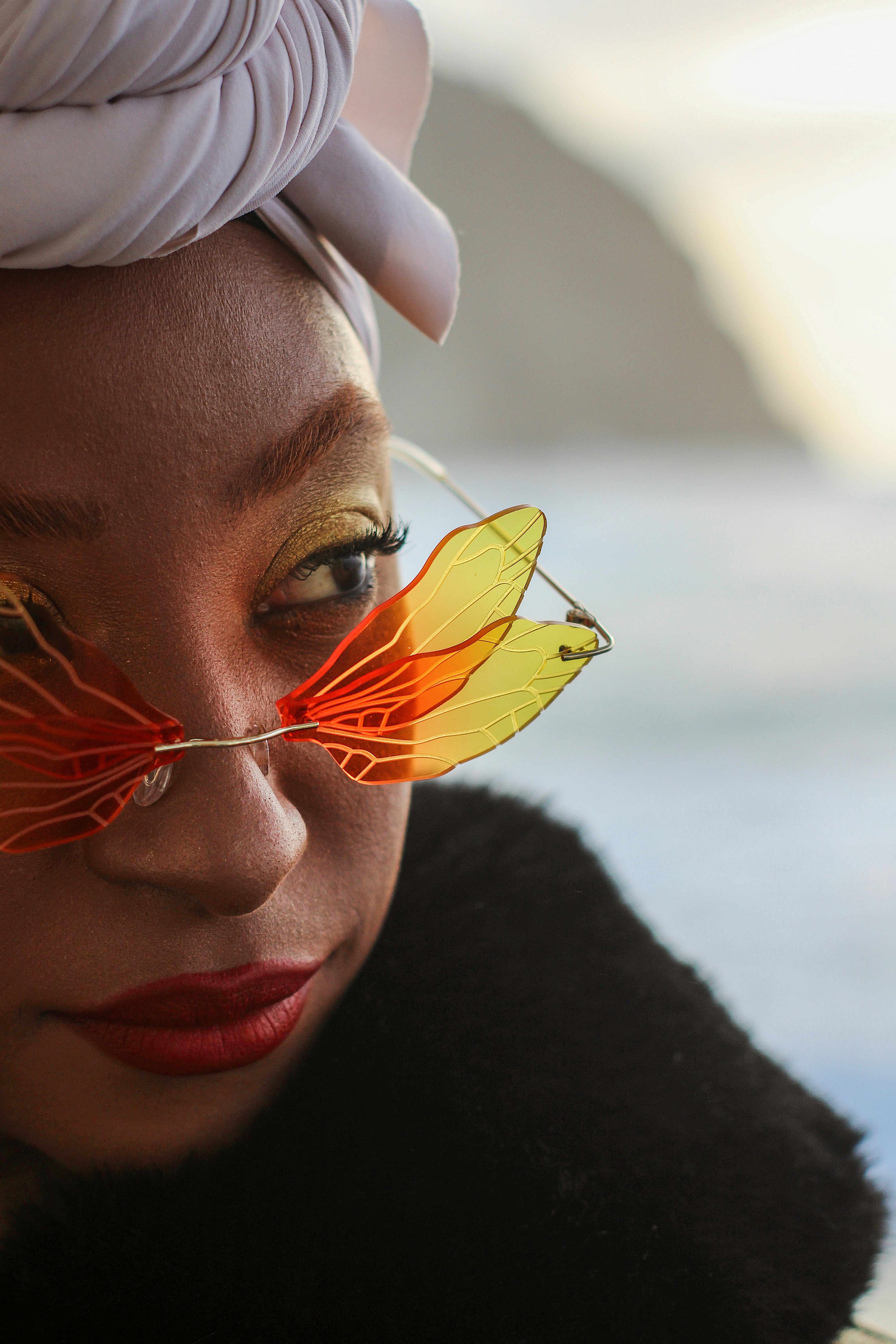 Bright Orange Glasses, Warm Gaze: A Close-Up by the Sea
