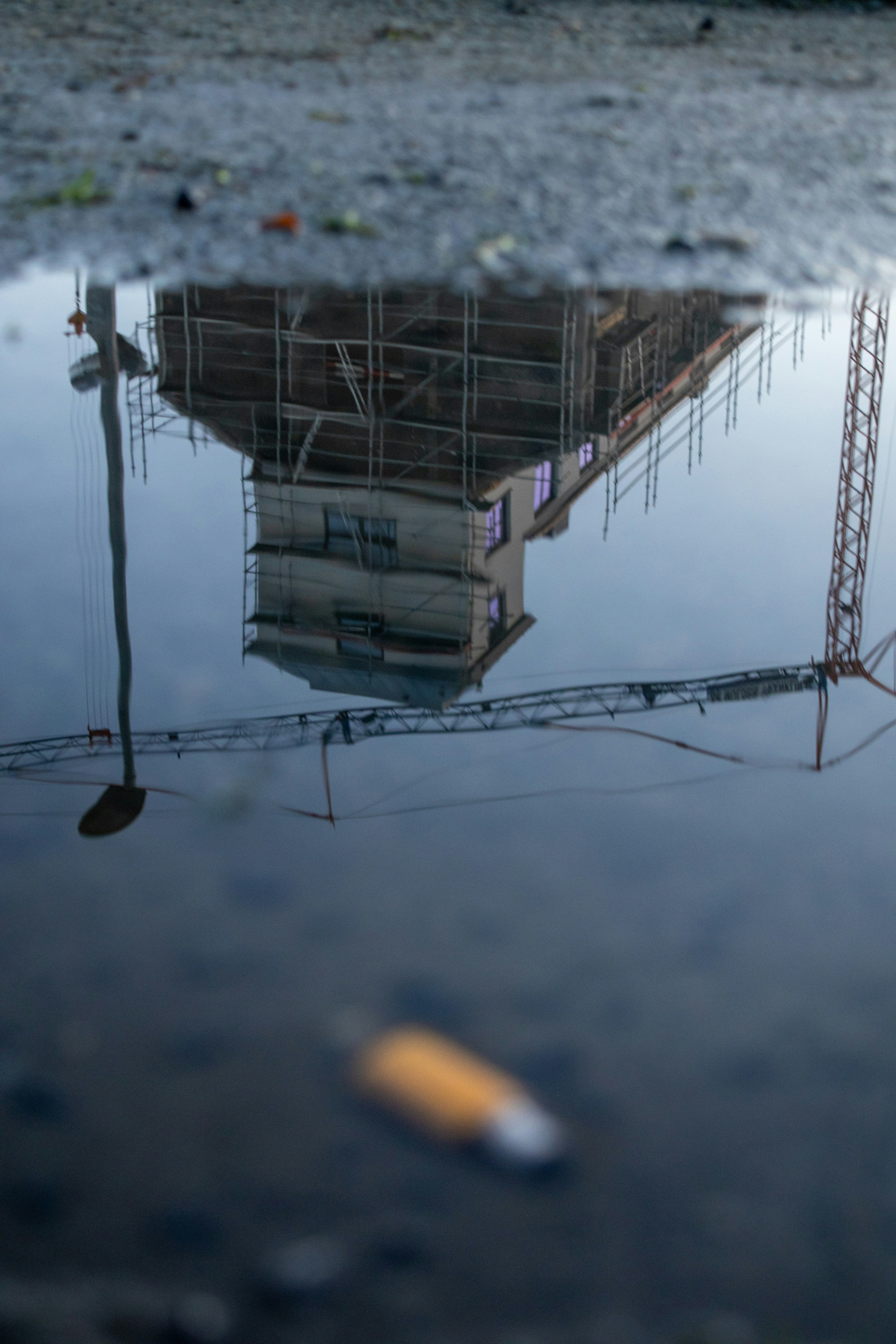 Liquid Skyline: Construction Tower Reflected in a City Puddle