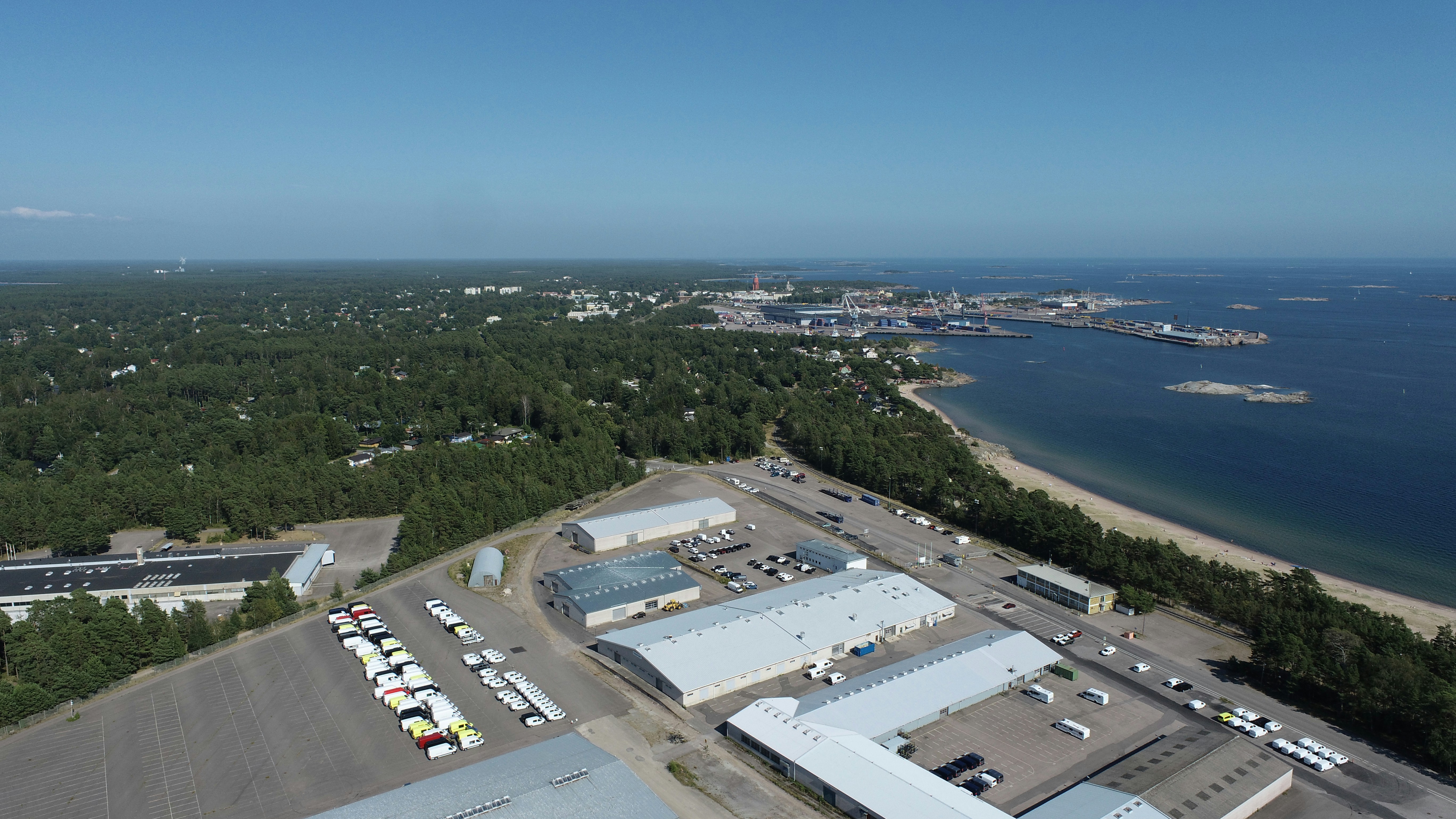 Coastal Industrial Quarter from Above: Docks, Warehouses, and Green Buffer