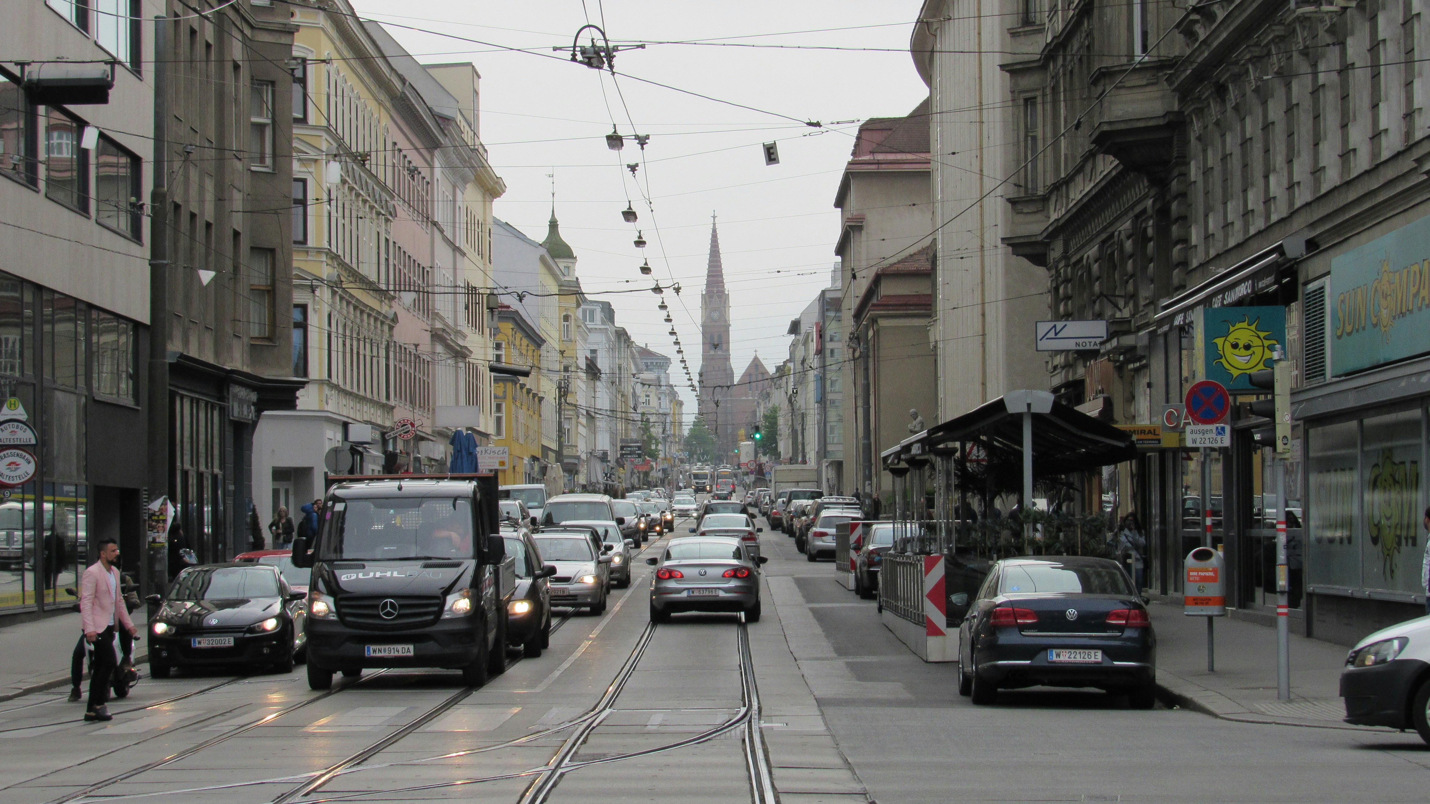 A city street filled with lots of traffic next to tall buildings photo ...