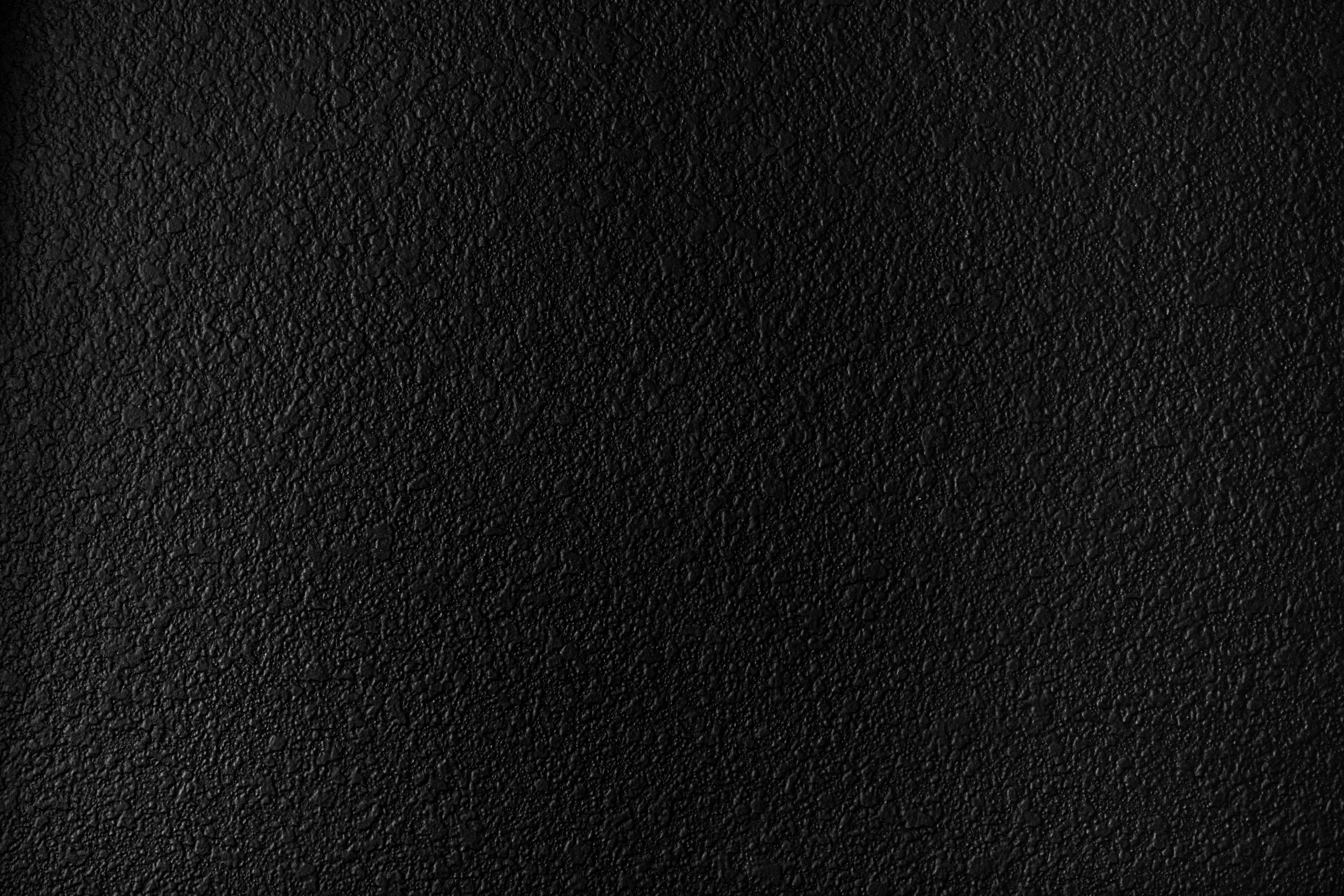 Close-up of a textured black surface, revealing intricate patterns and depth. Perfect for backgrounds or design elements.