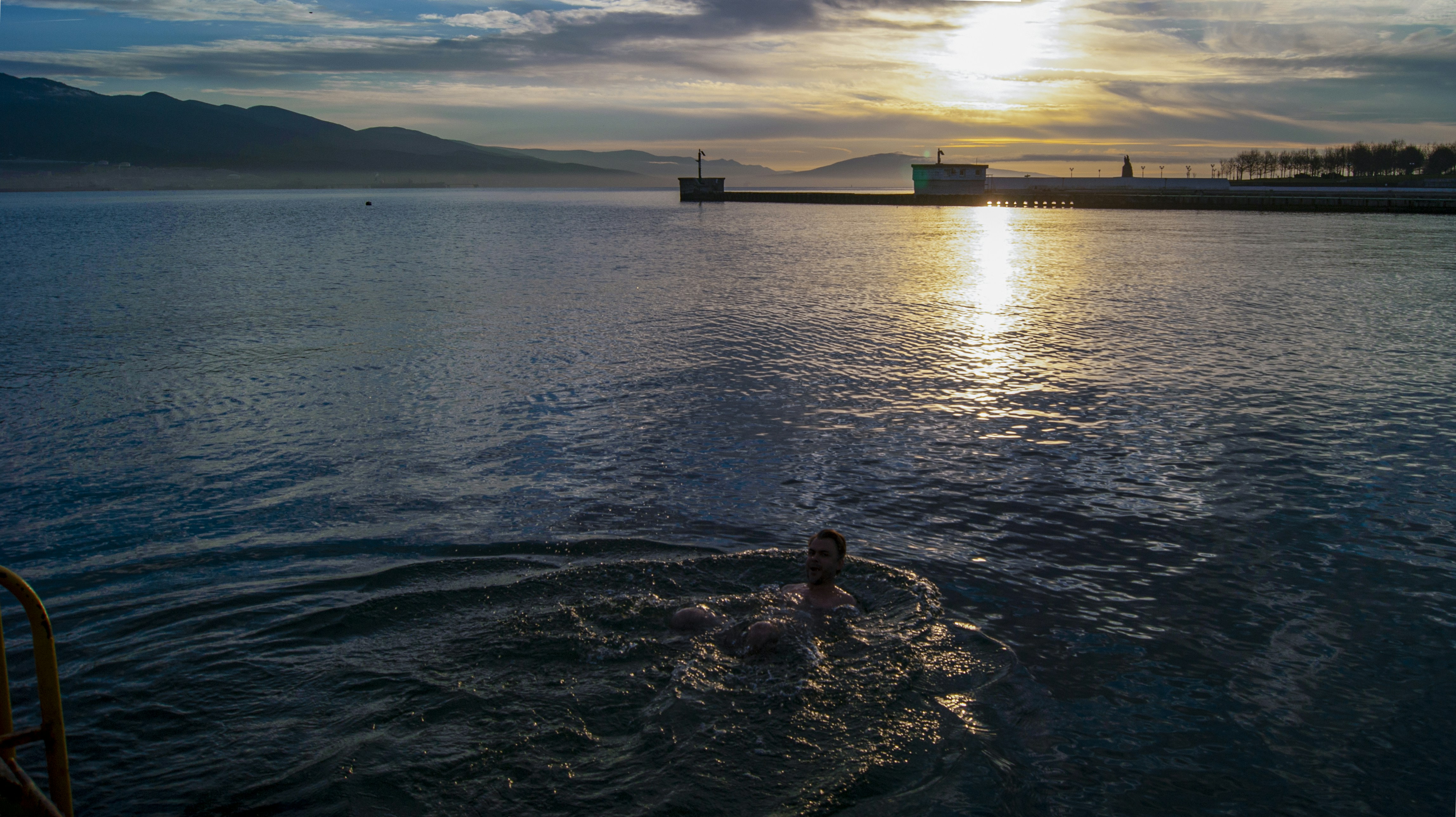 Harbor Sunset: Ripples and a Lone Swimmer
