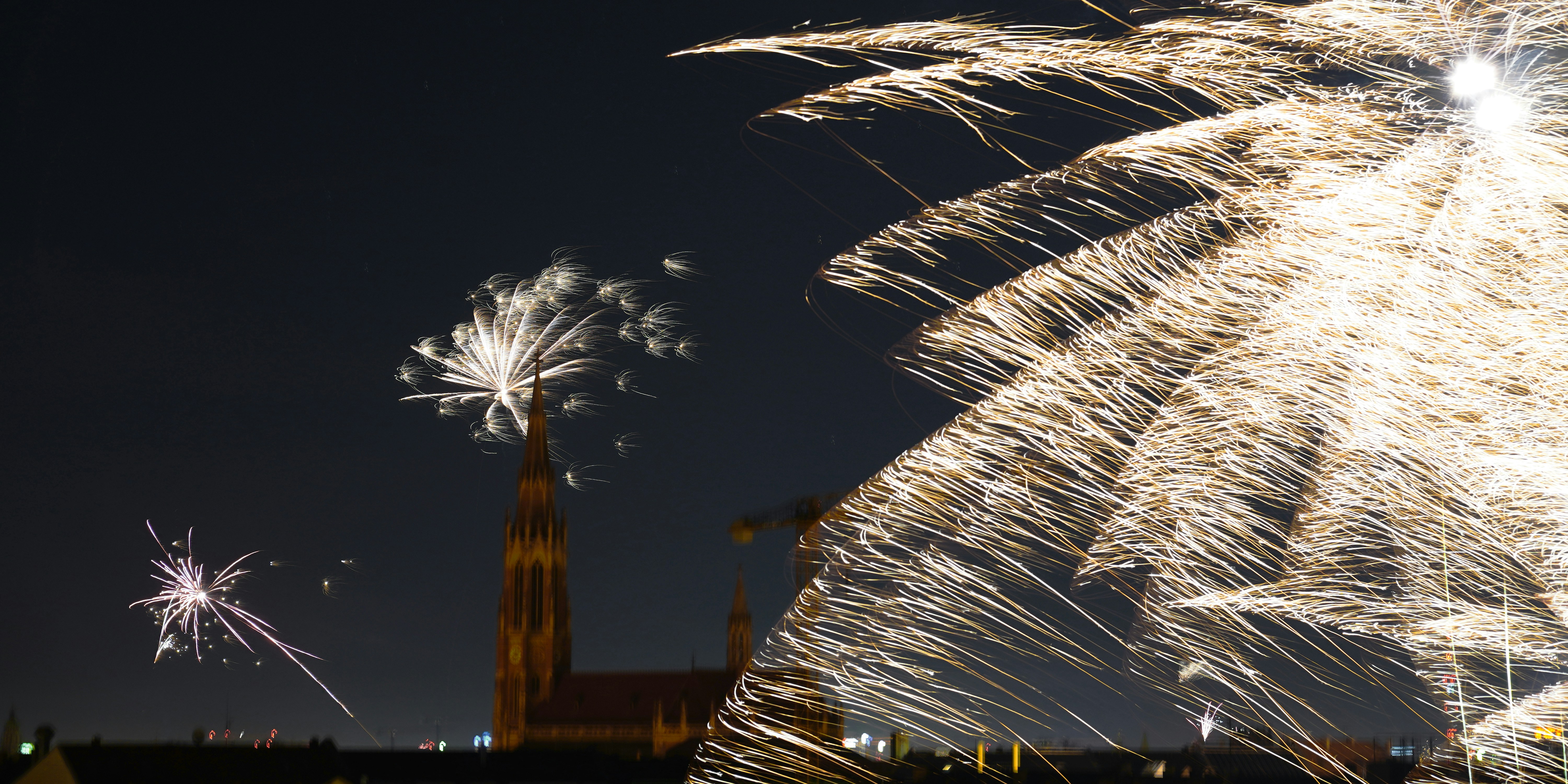 Night Sky Firework Cascade Above a Landmark Spire