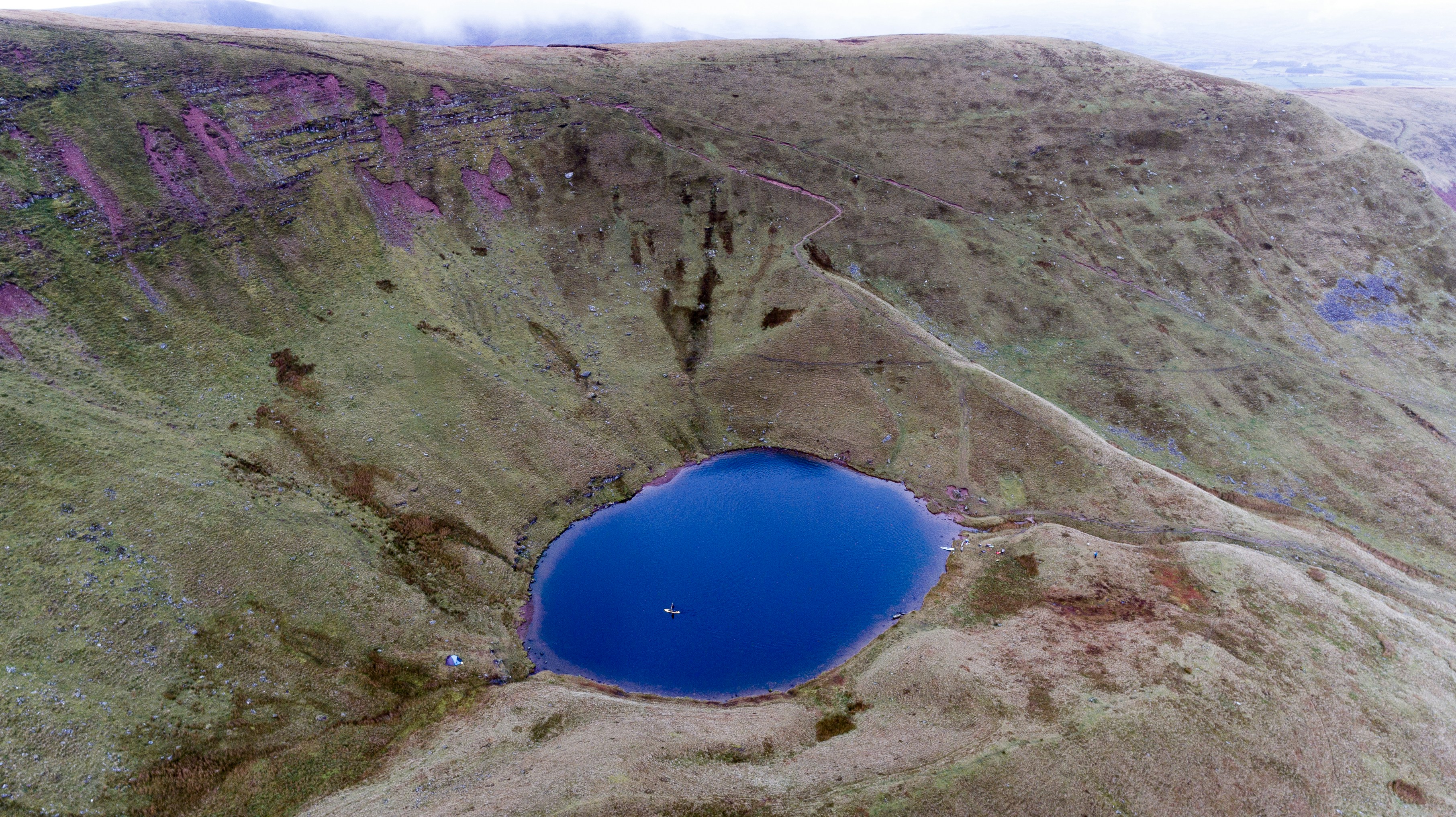 Azure Caldera: A Blue Crater Lake Crowned by Wind-swept Hills