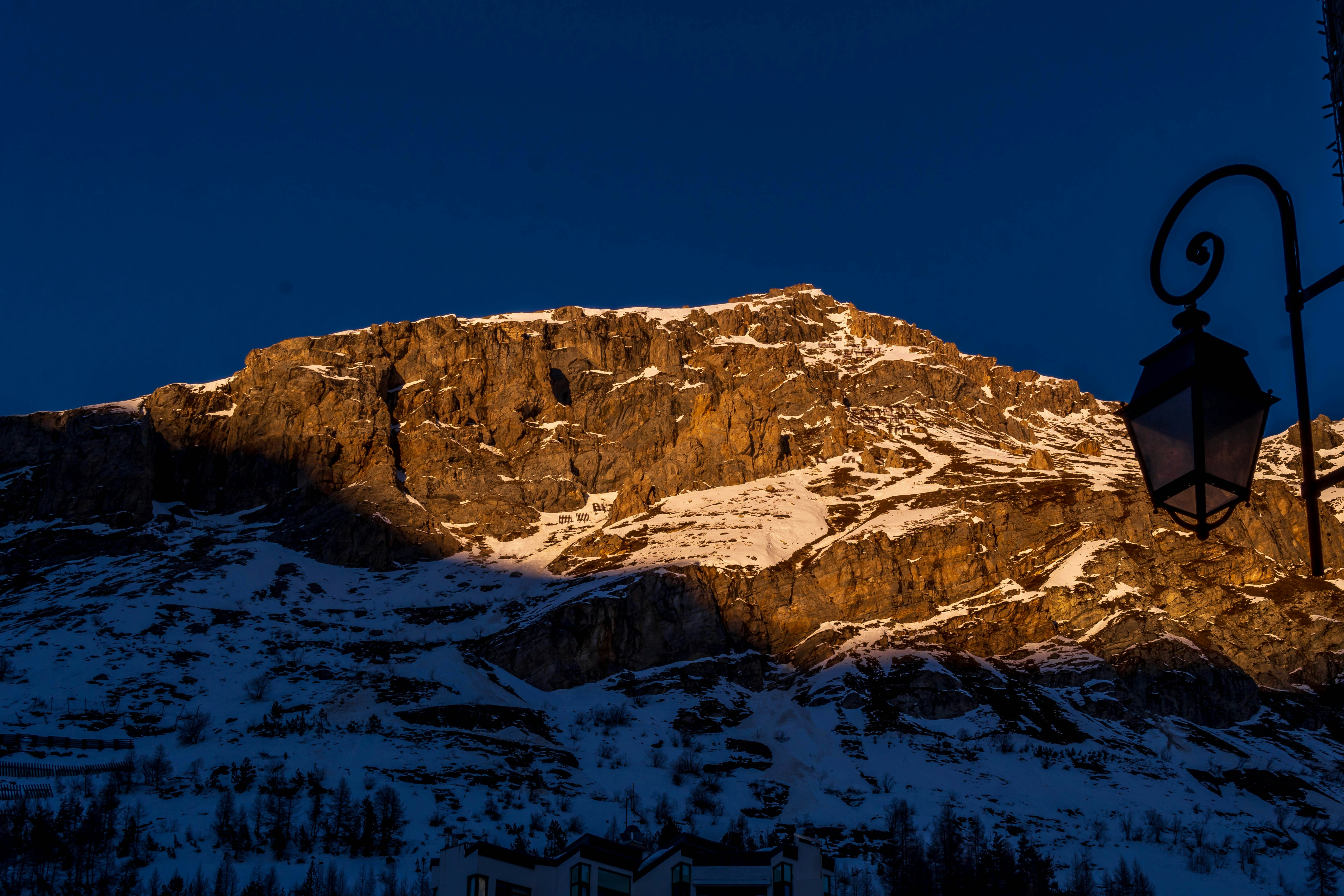 a street light in front of a snow covered mountainMatt Pictures