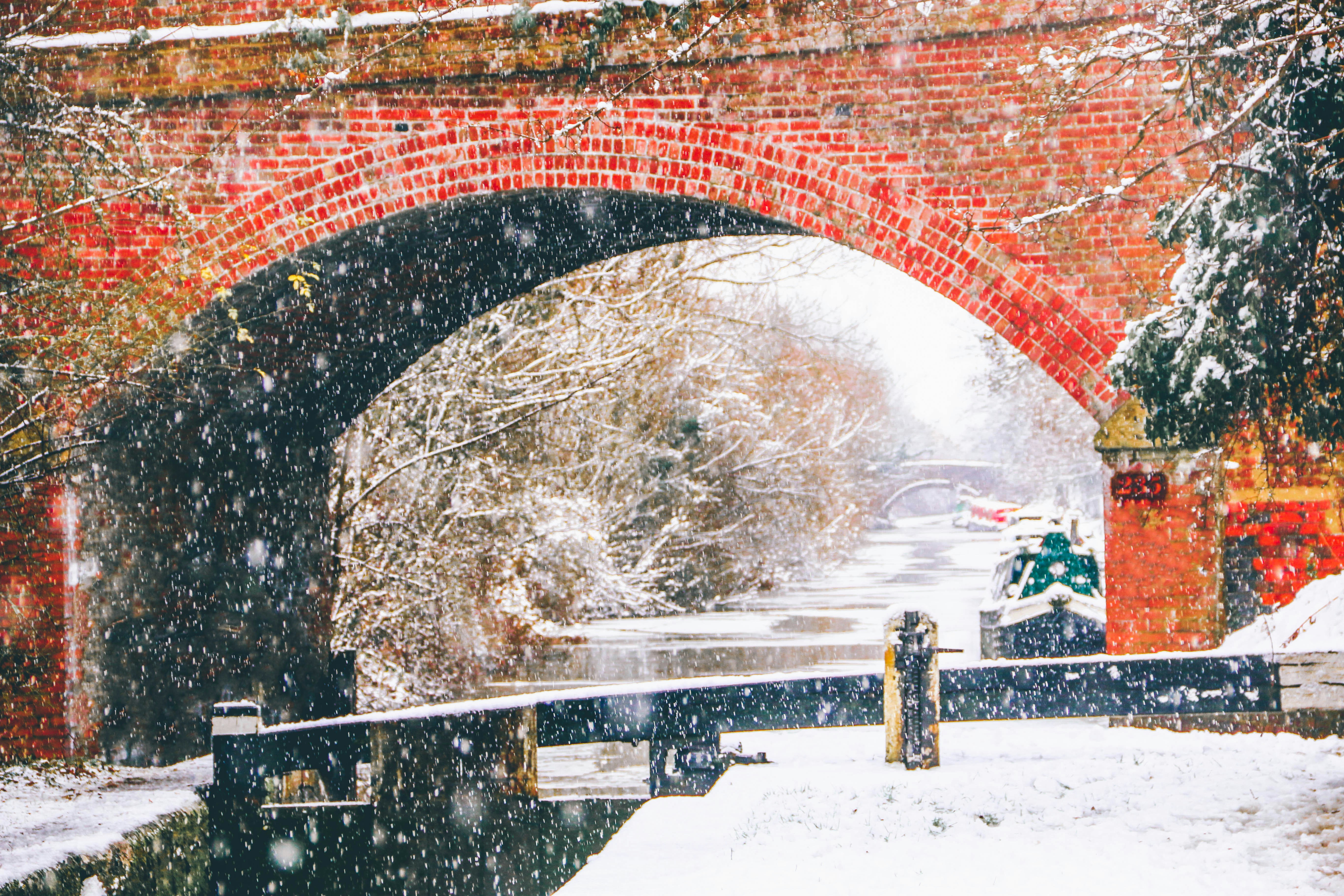 a bridge over a river with snow falling on it