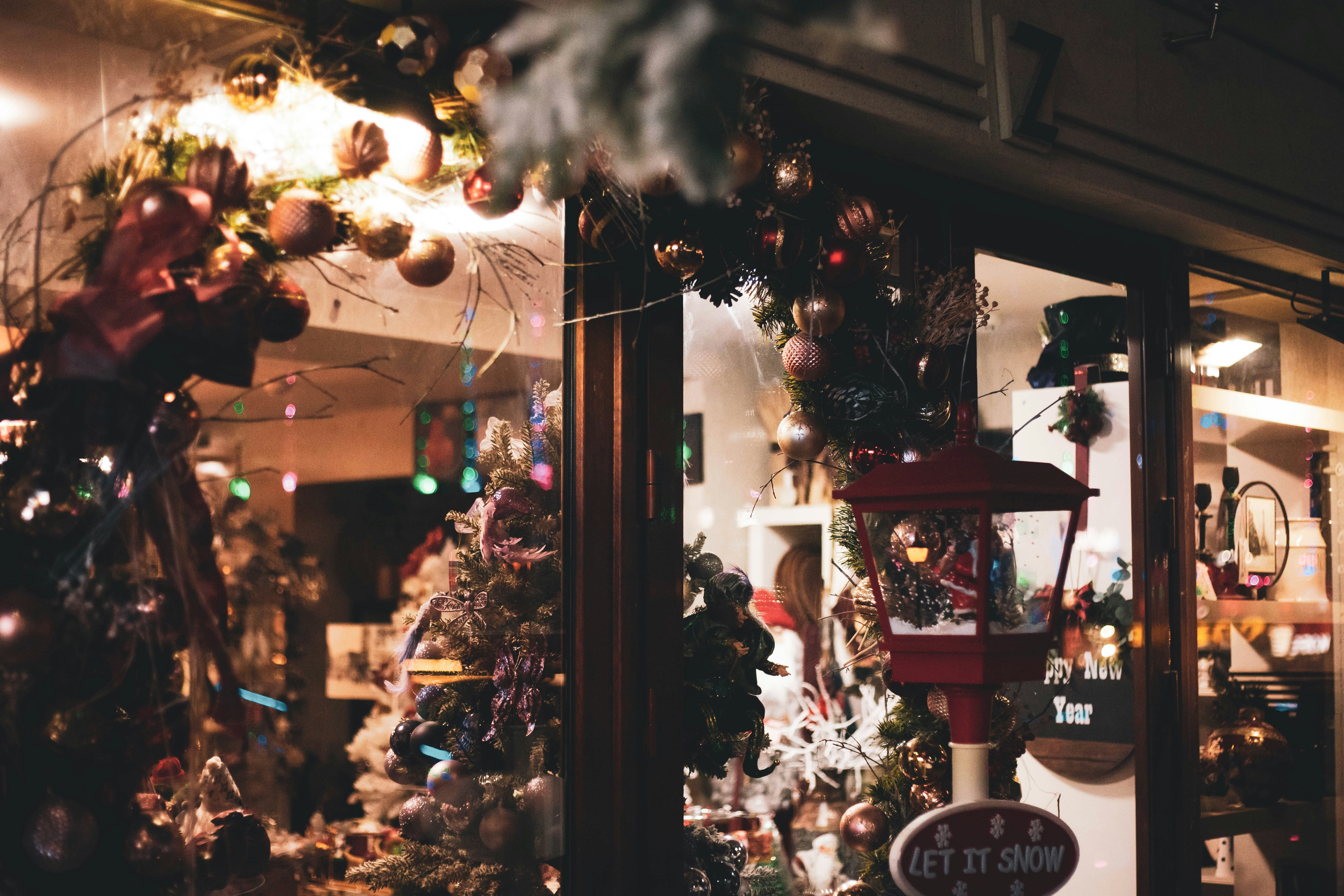 Festively decorated shop window with twinkling lights and holiday ornaments.