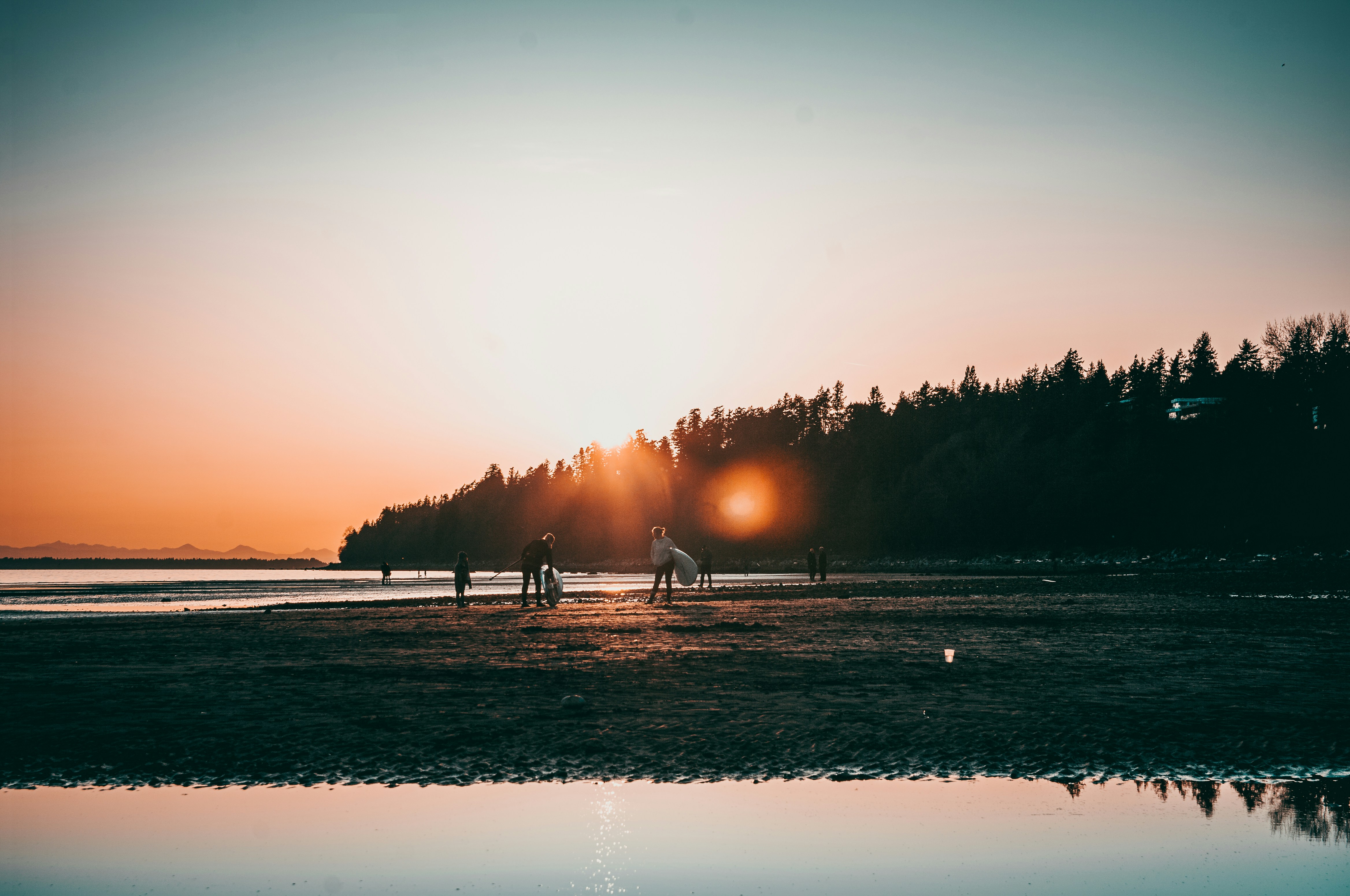 Sunset on the Shore: Silhouetted Figures and a Quiet Dune