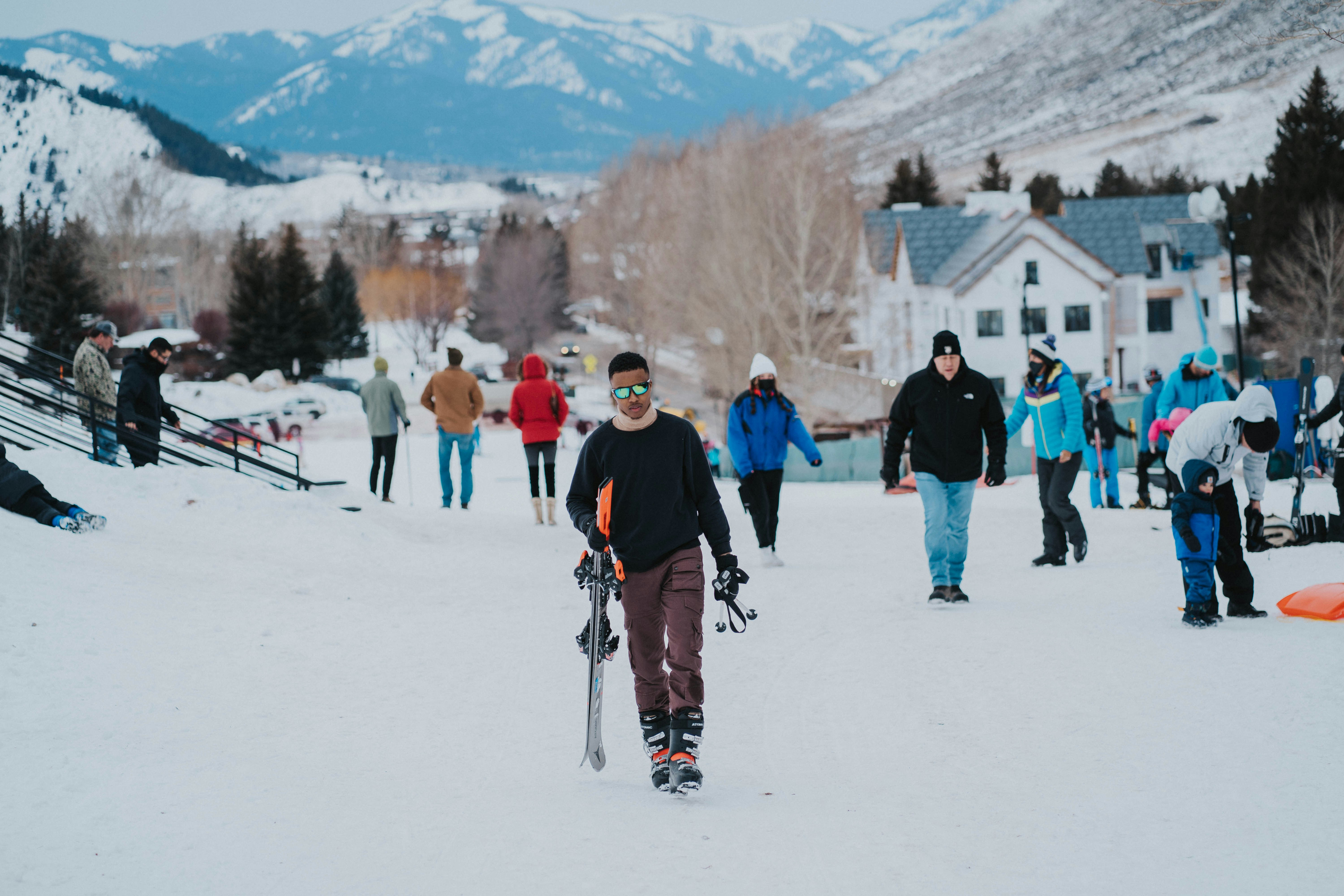 Snowfront Surfer: A lone skier strides toward the village amid a bustling winter gathering