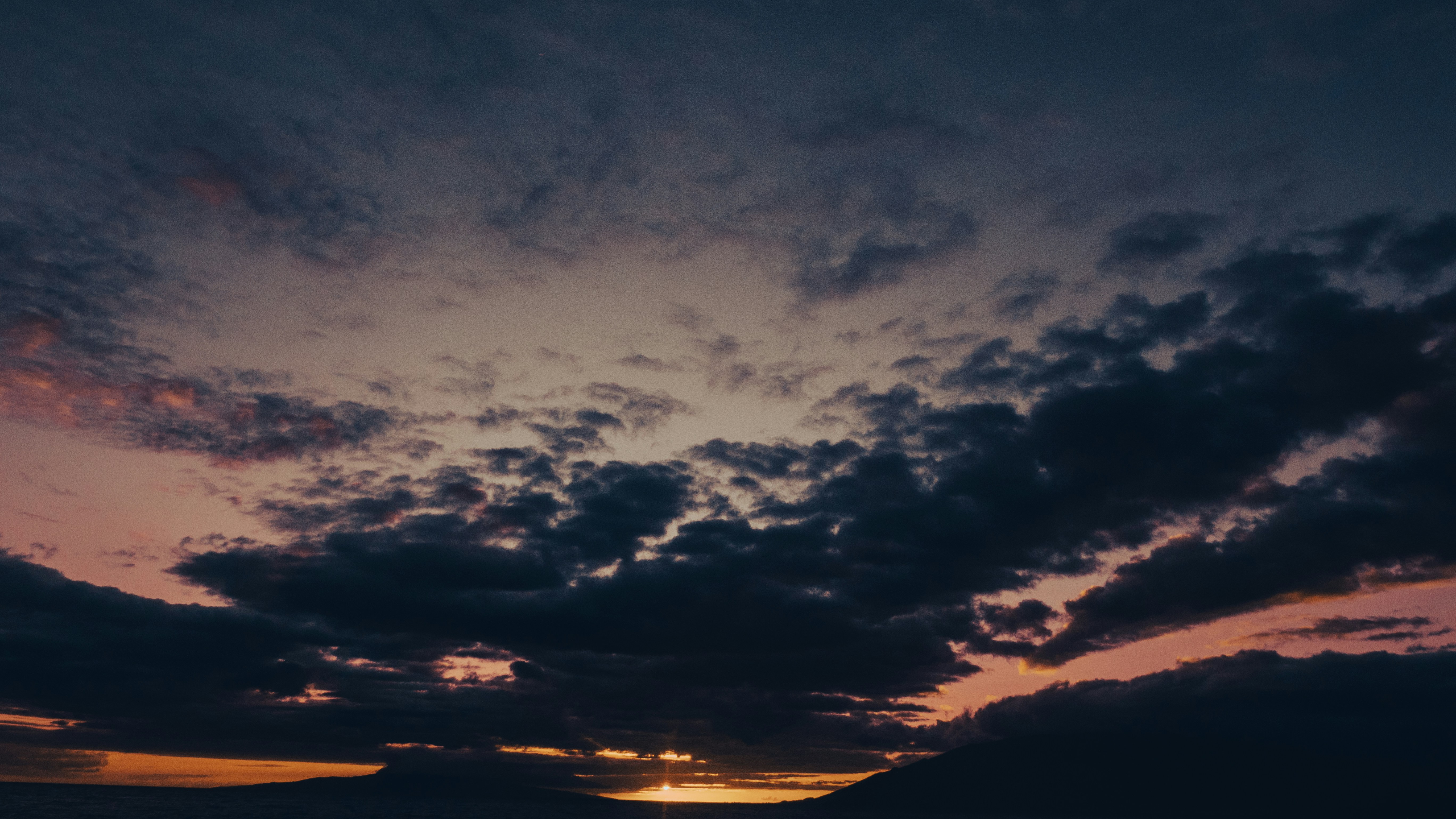 the sun is setting over the ocean with clouds in the skyKellen Riggin