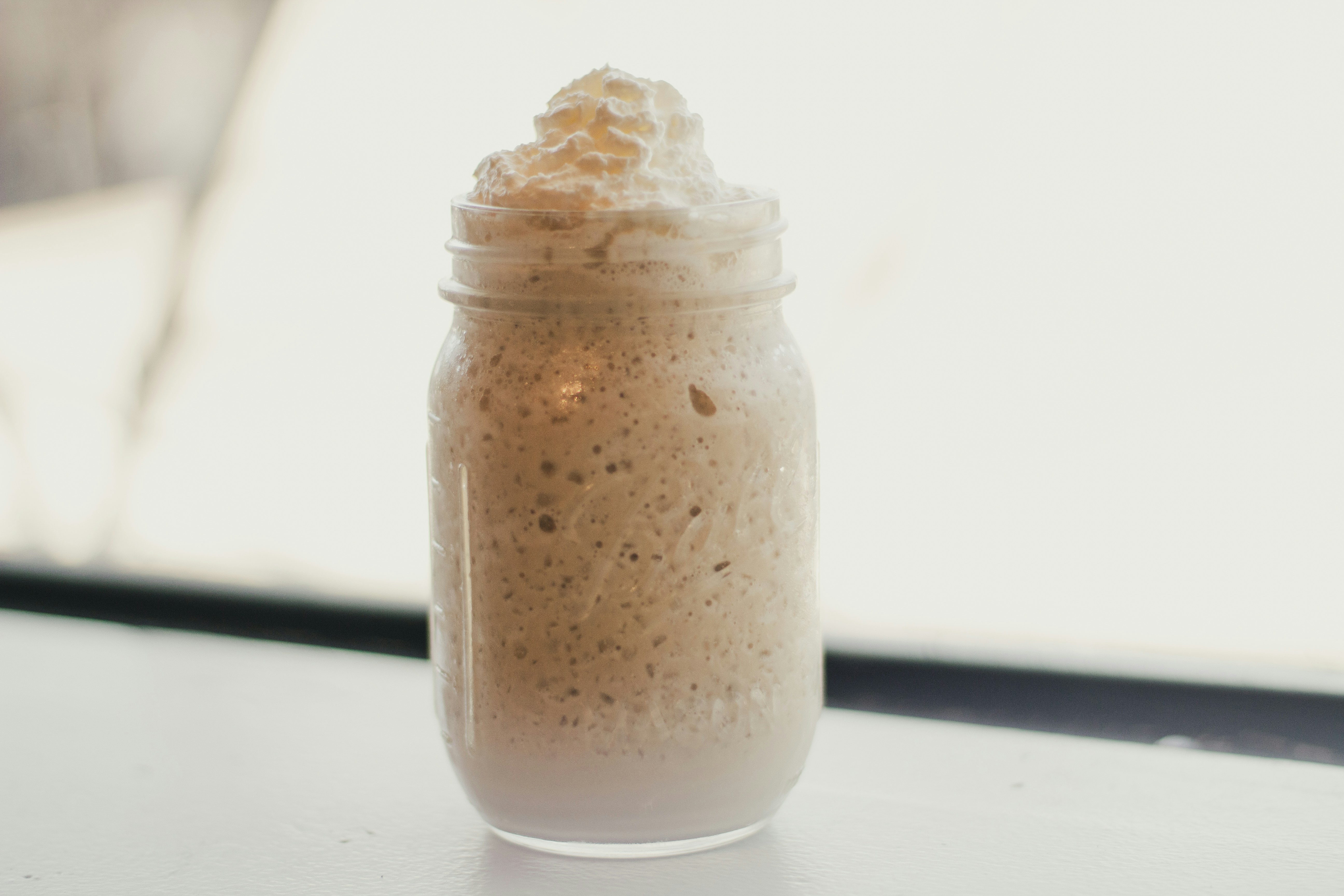 Un bocal en verre rempli d’une boisson assis sur une table photo ...