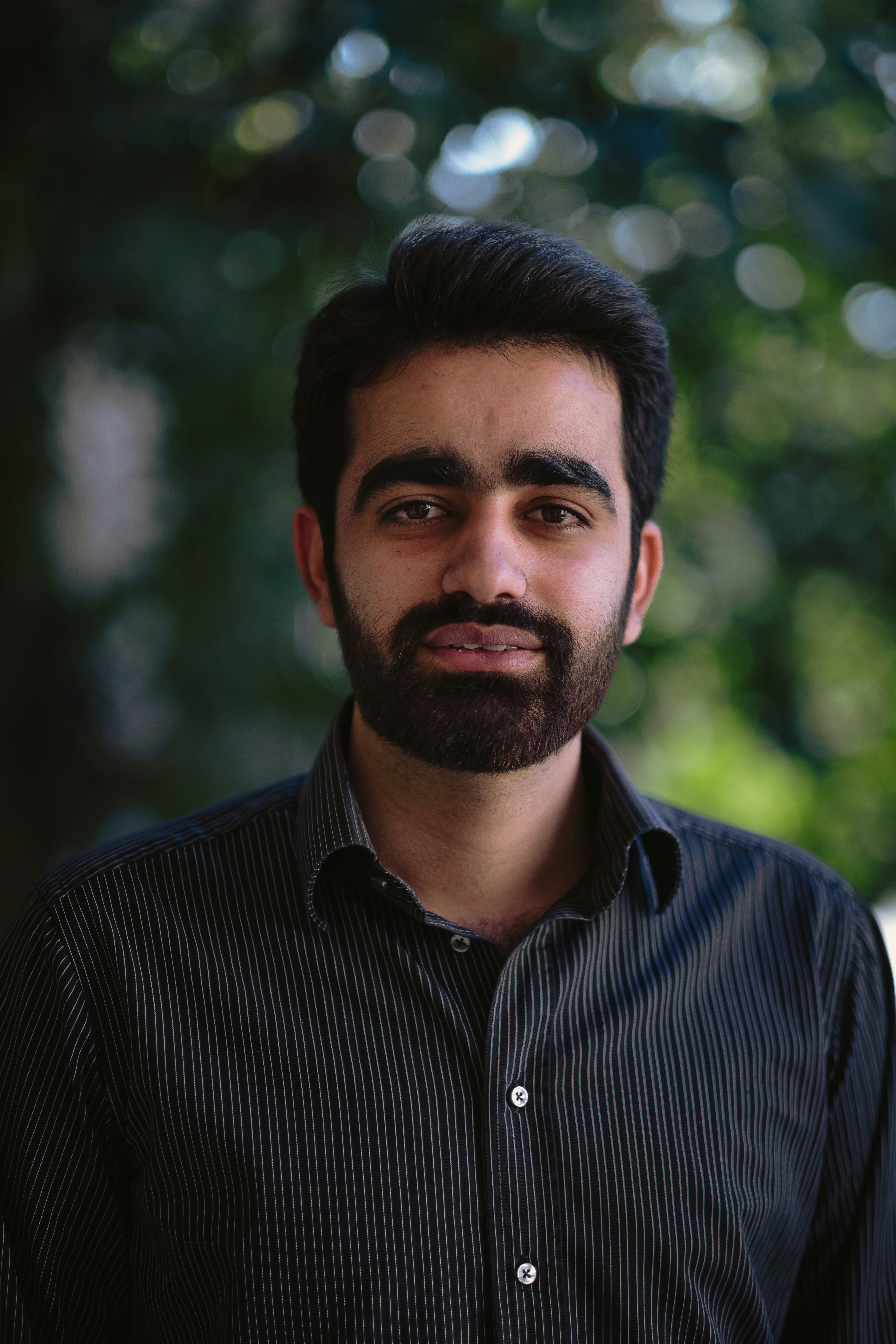 A man with a beard standing in front of a tree photo – Free Iraq Image ...