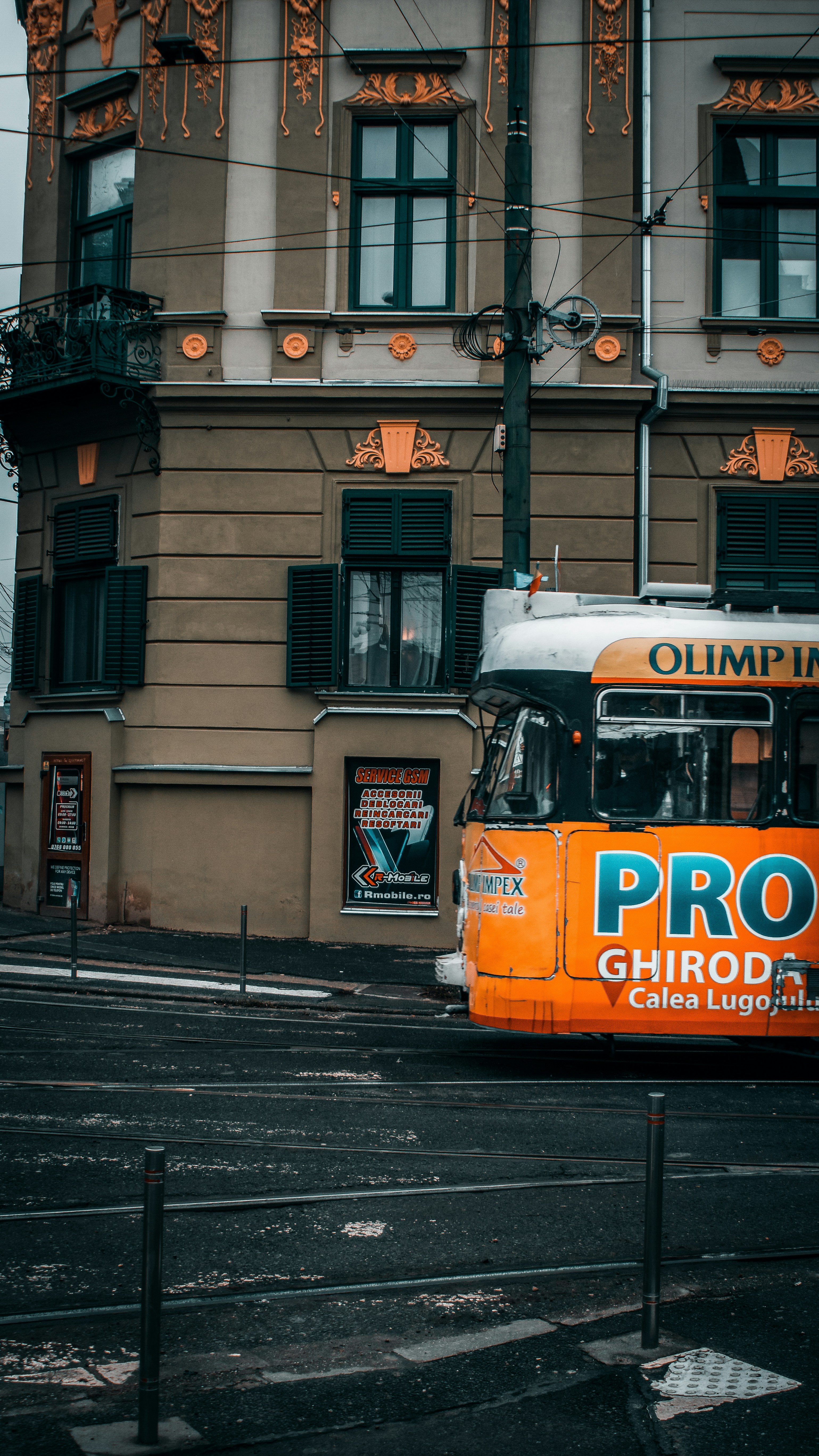 Un bus orange et blanc garé devant un immeuble photo – Photo Bus ...