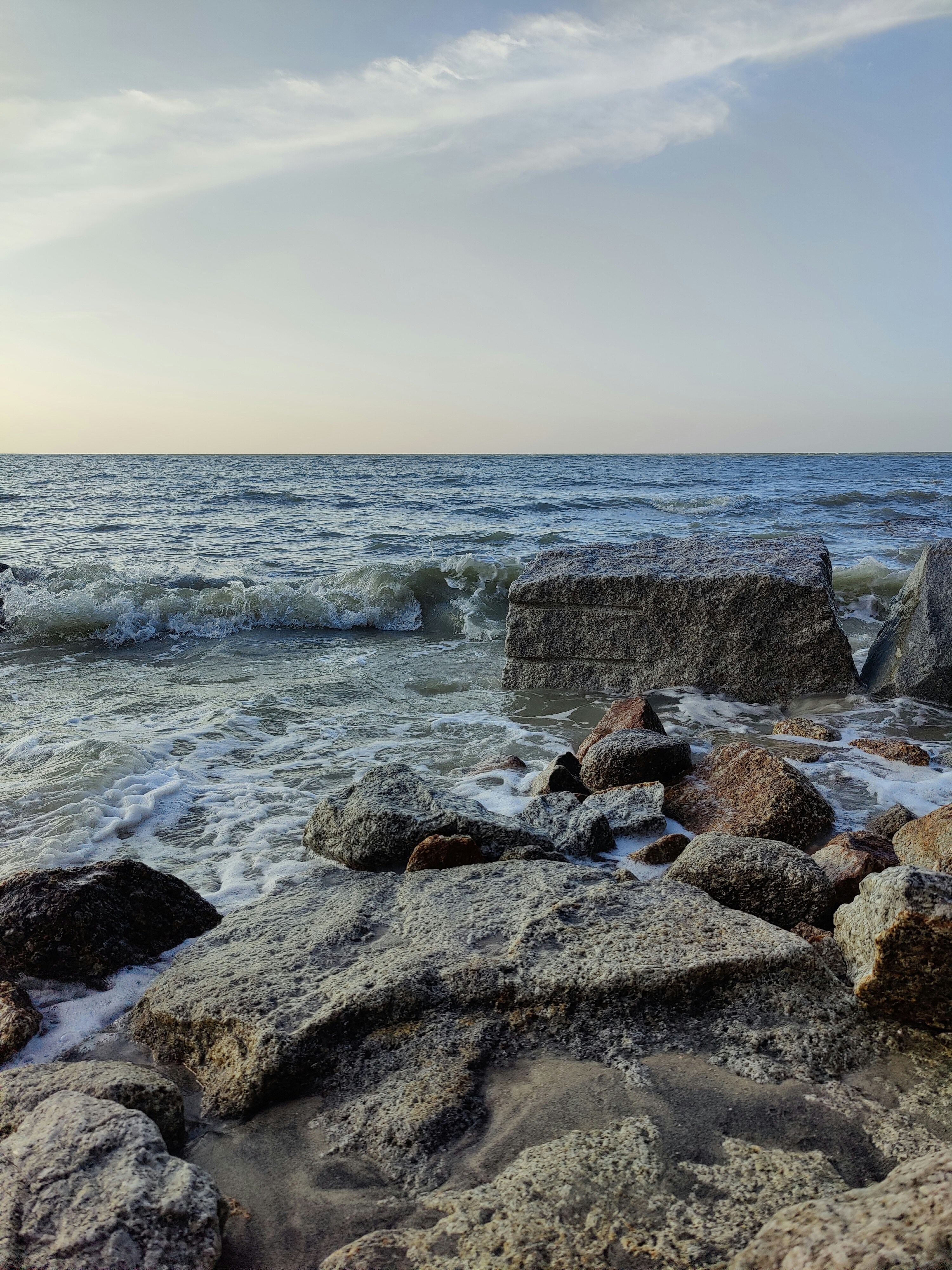 Foto zum Thema Ein felsiger Strand mit Wellen, die ins und aus dem ...