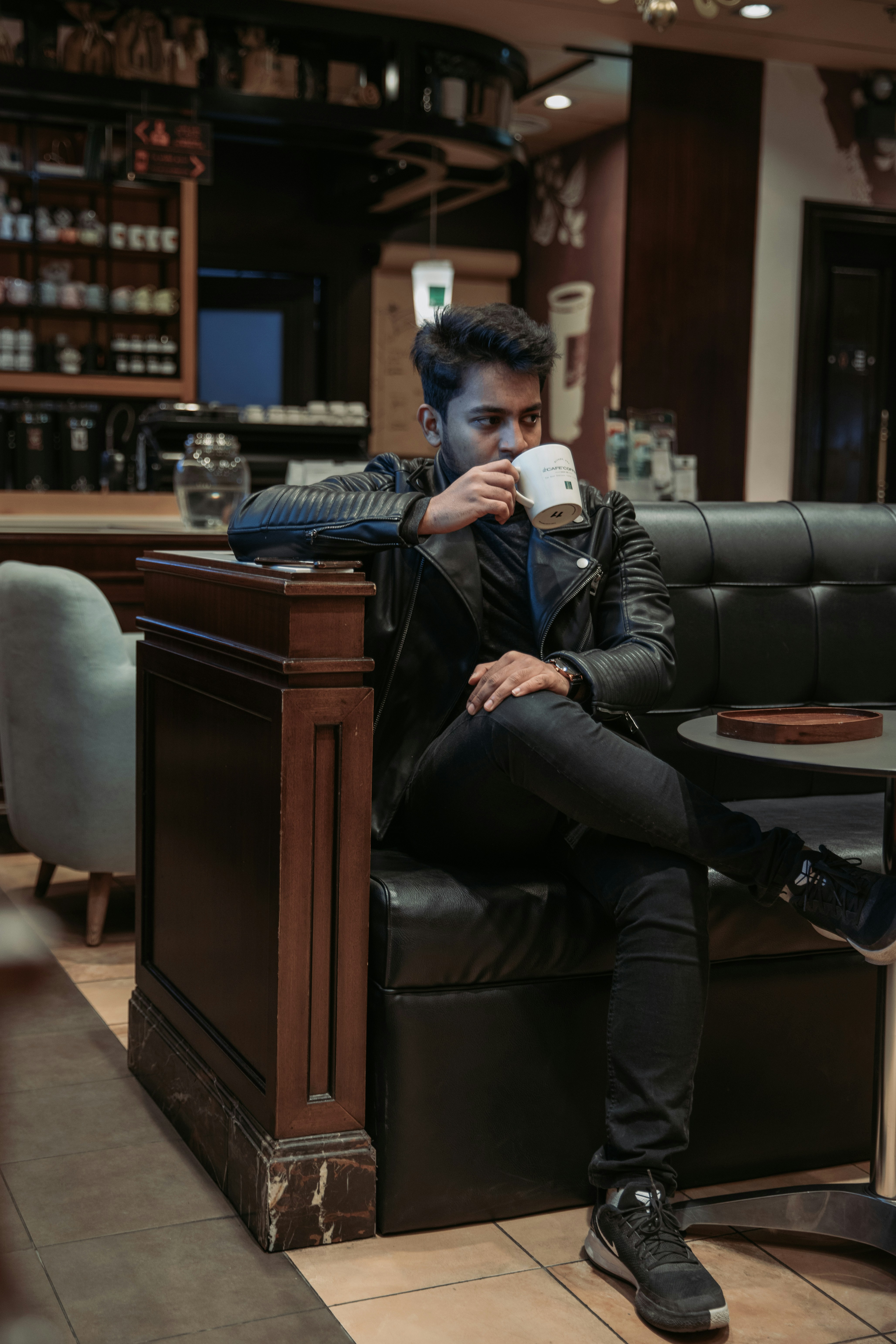 Foto Un hombre sentado en una silla bebiendo una taza de café – Imagen ...