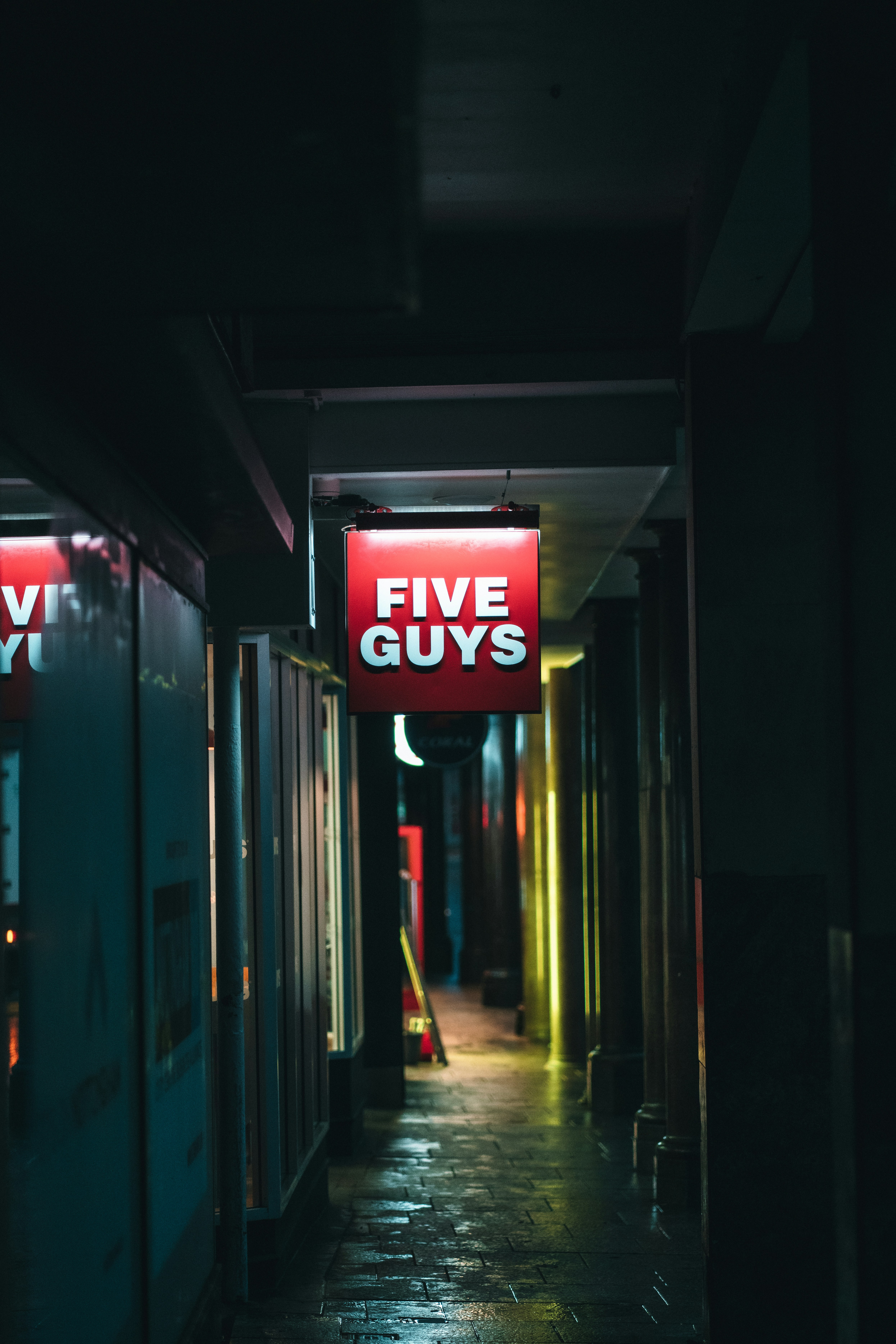 A red five guys sign hanging from the side of a building photo – Free ...
