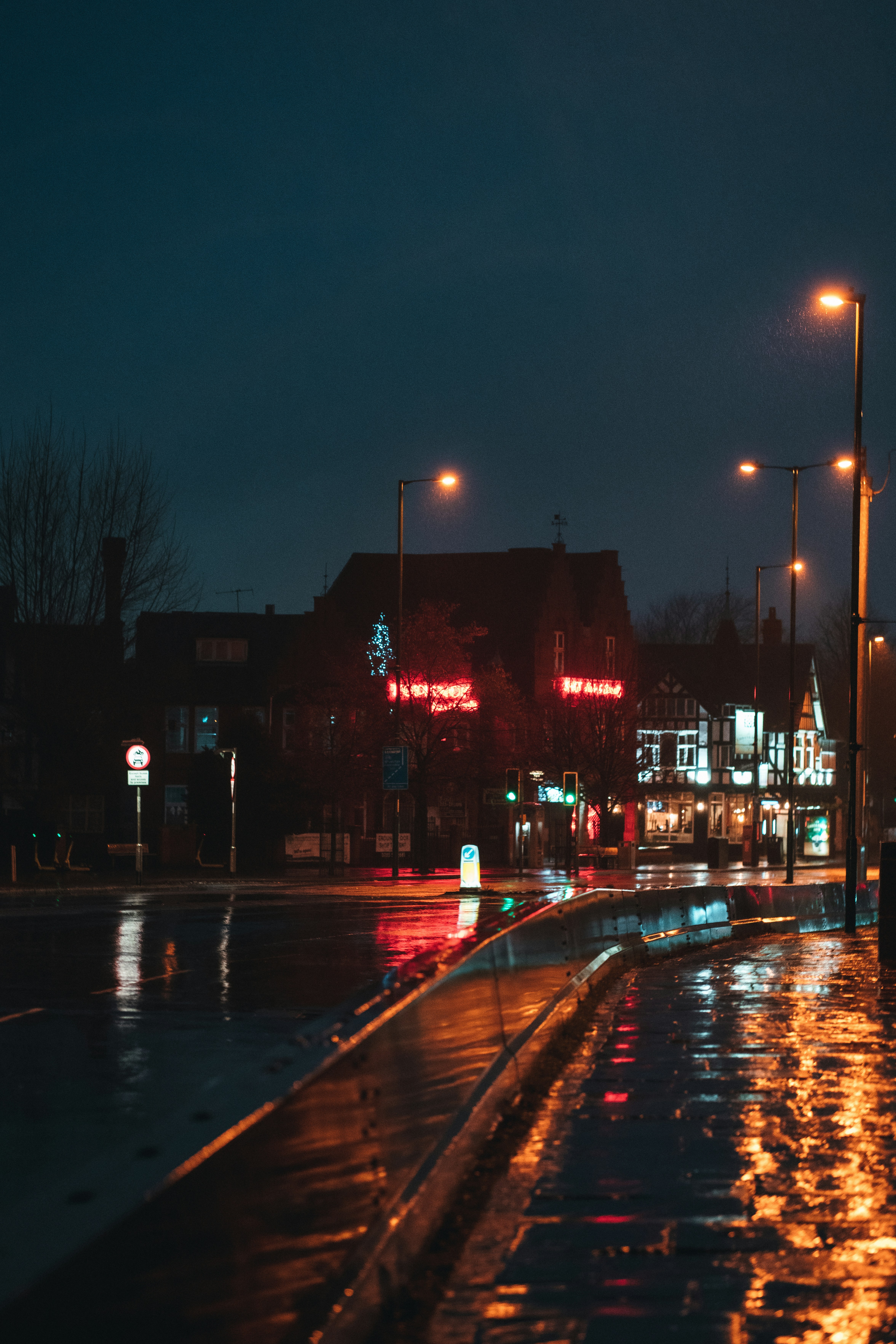 Foto zum Thema Eine nasse Stadtstraße bei Nacht mit Straßenlaternen ...