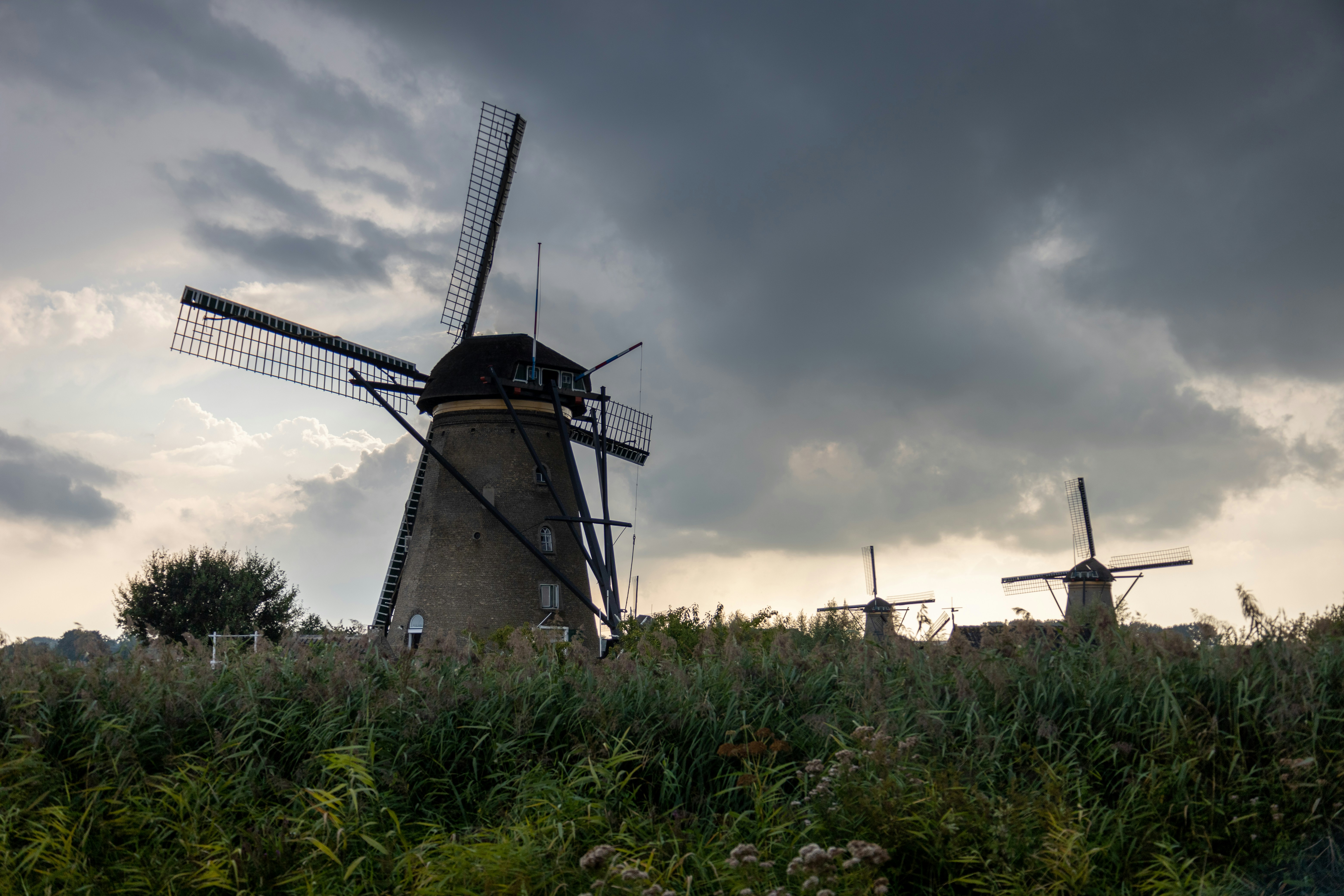 a group of windmills sitting on top of a lush green field