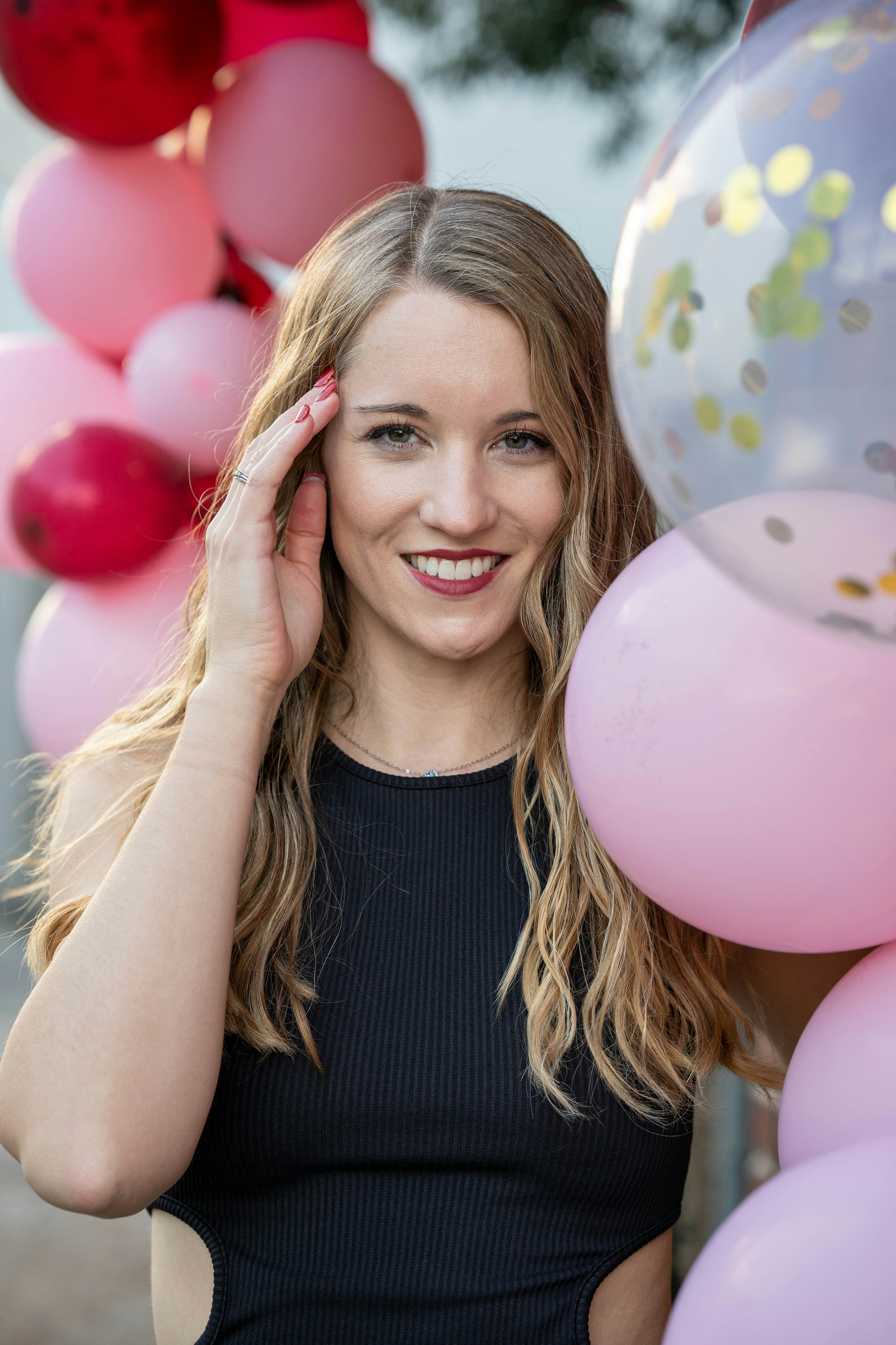 A woman standing in front of a bunch of balloons photo – Free Savannah ...