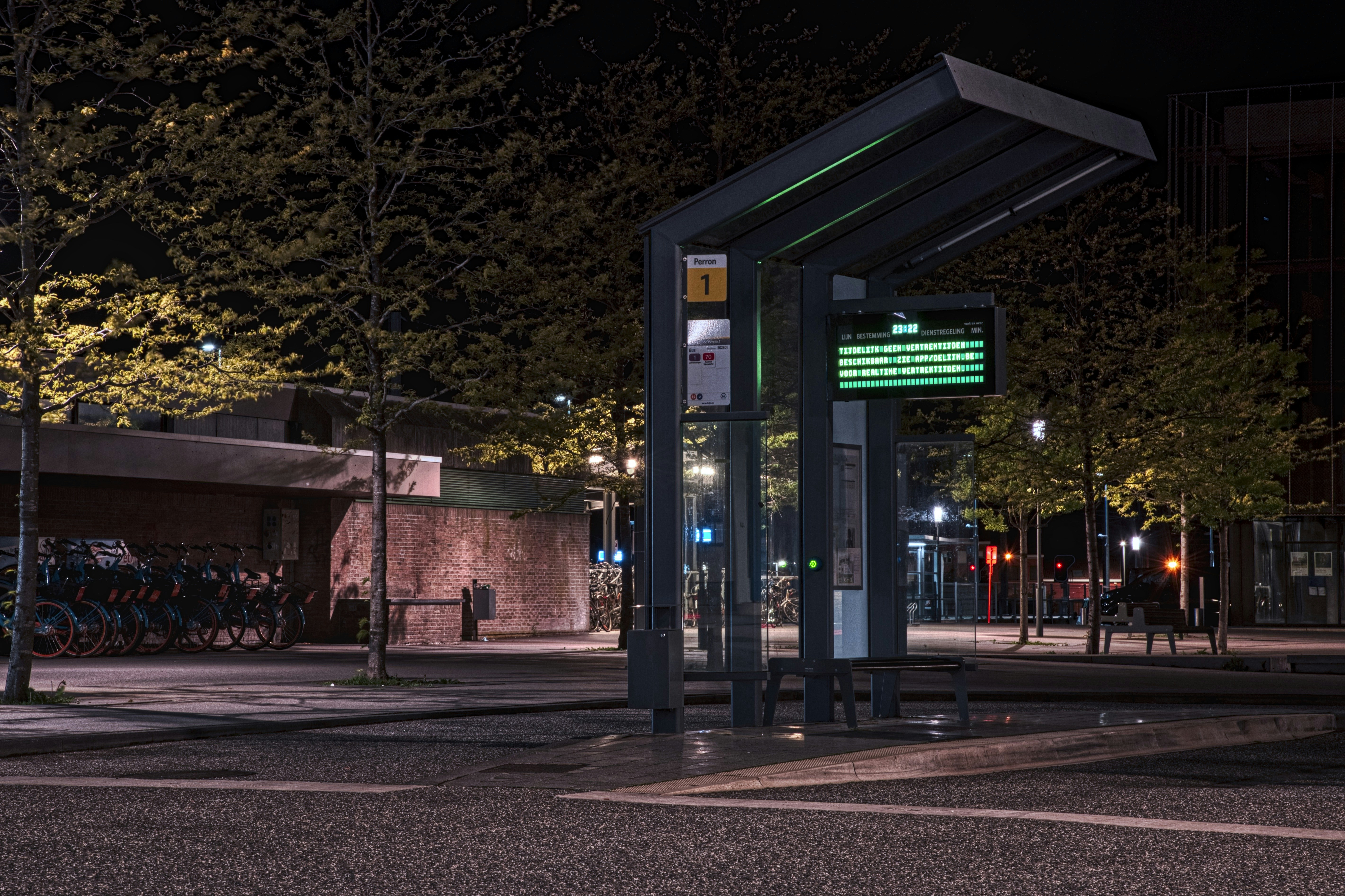 A bus stop on a city street at night photo – Free City Image on Unsplash