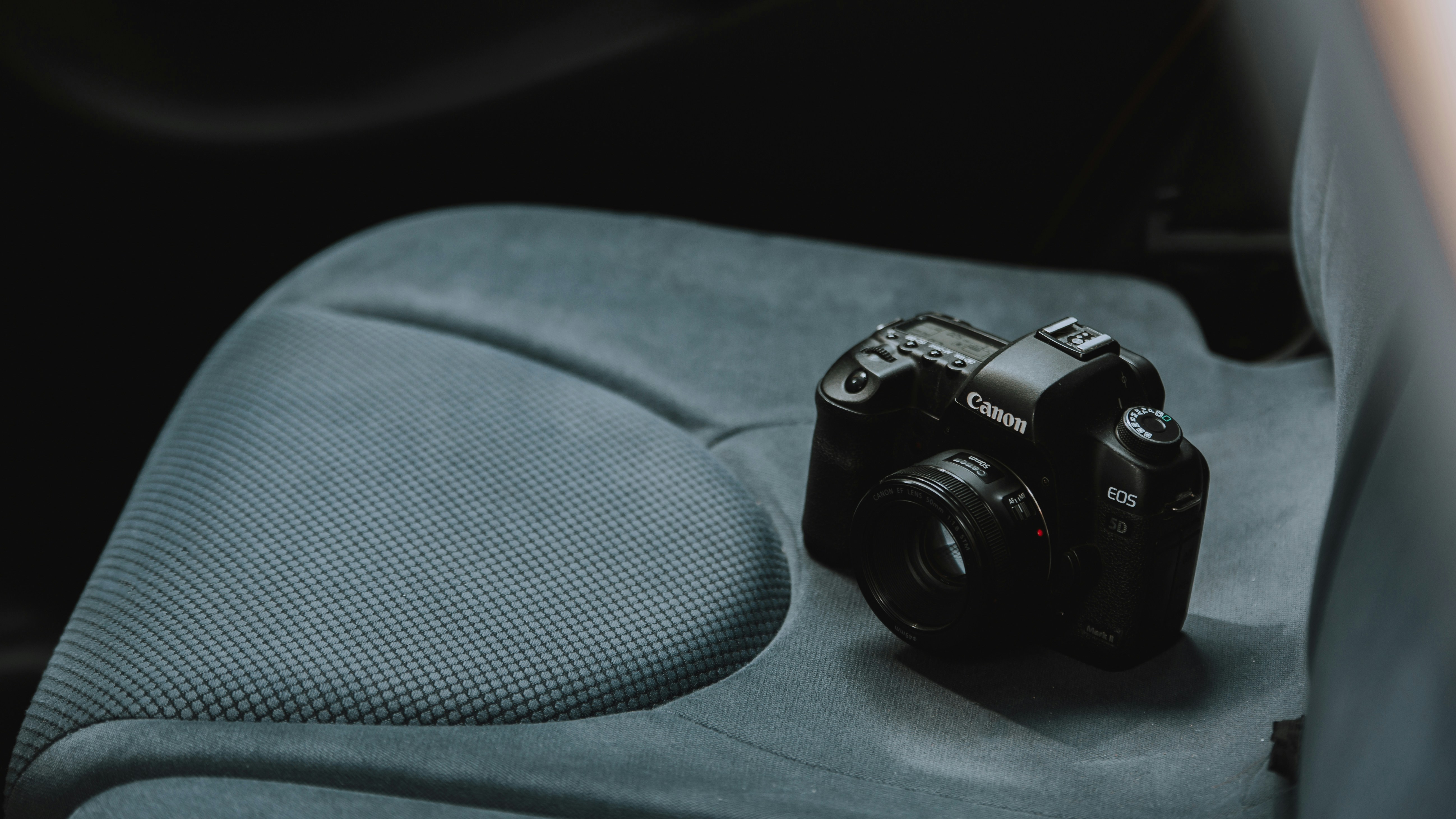 A couple of cameras sitting on top of a seat photo – Free Camera Image ...
